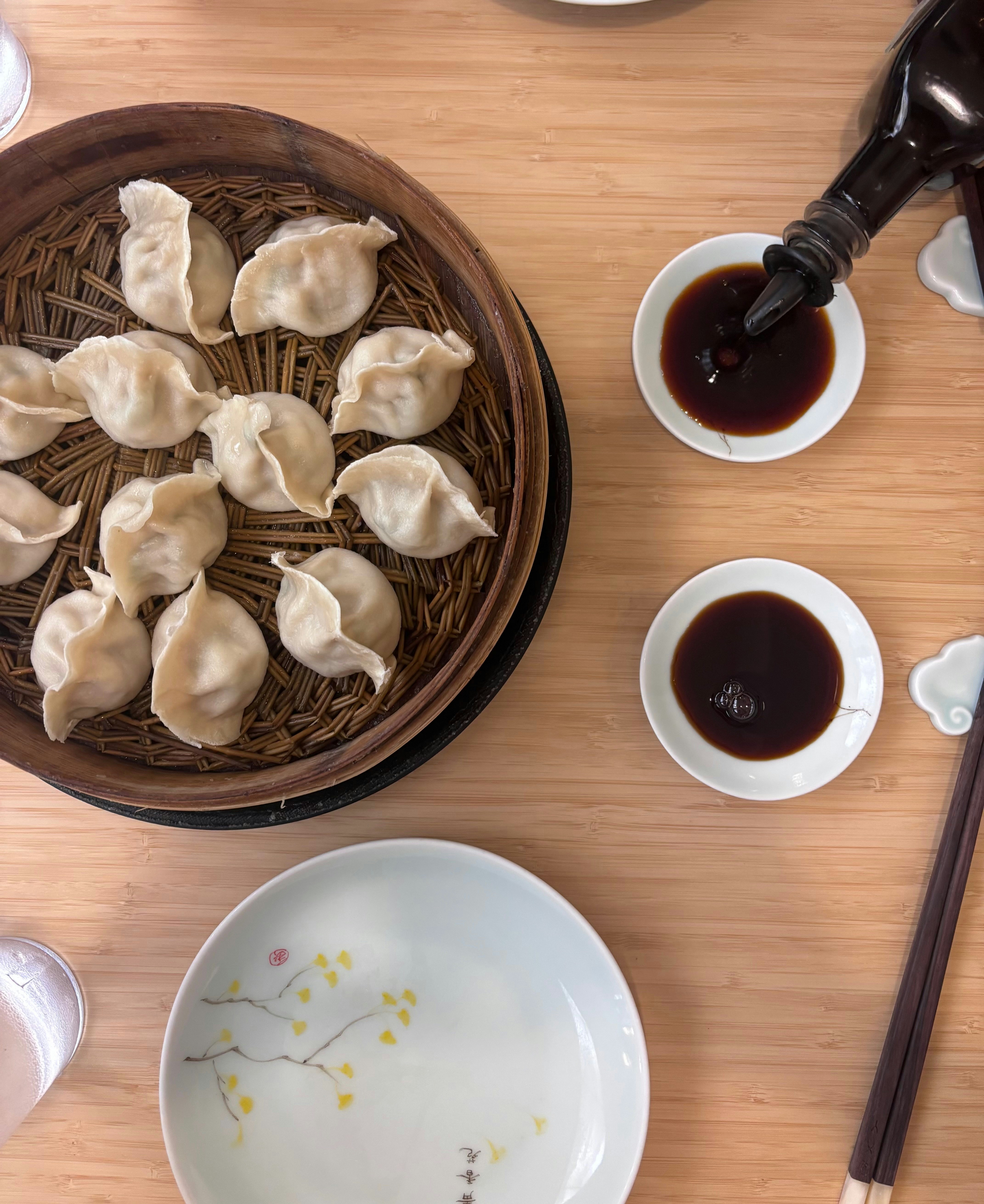 Steamed Dumplings on a Bamboo Tray beside Soy Sauces