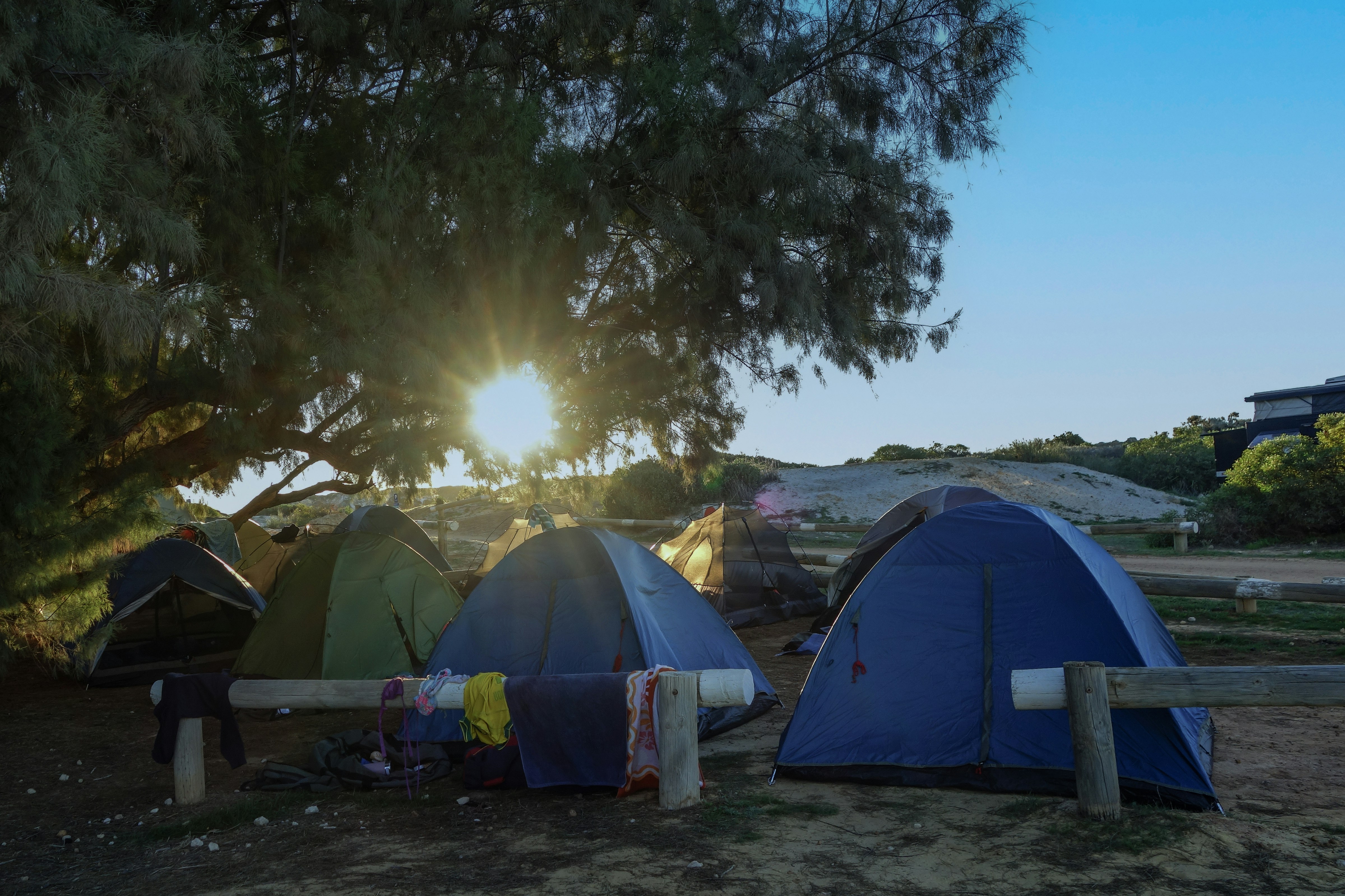 Dawn at the Camp: Sunlight Filtrates Through Tent Village