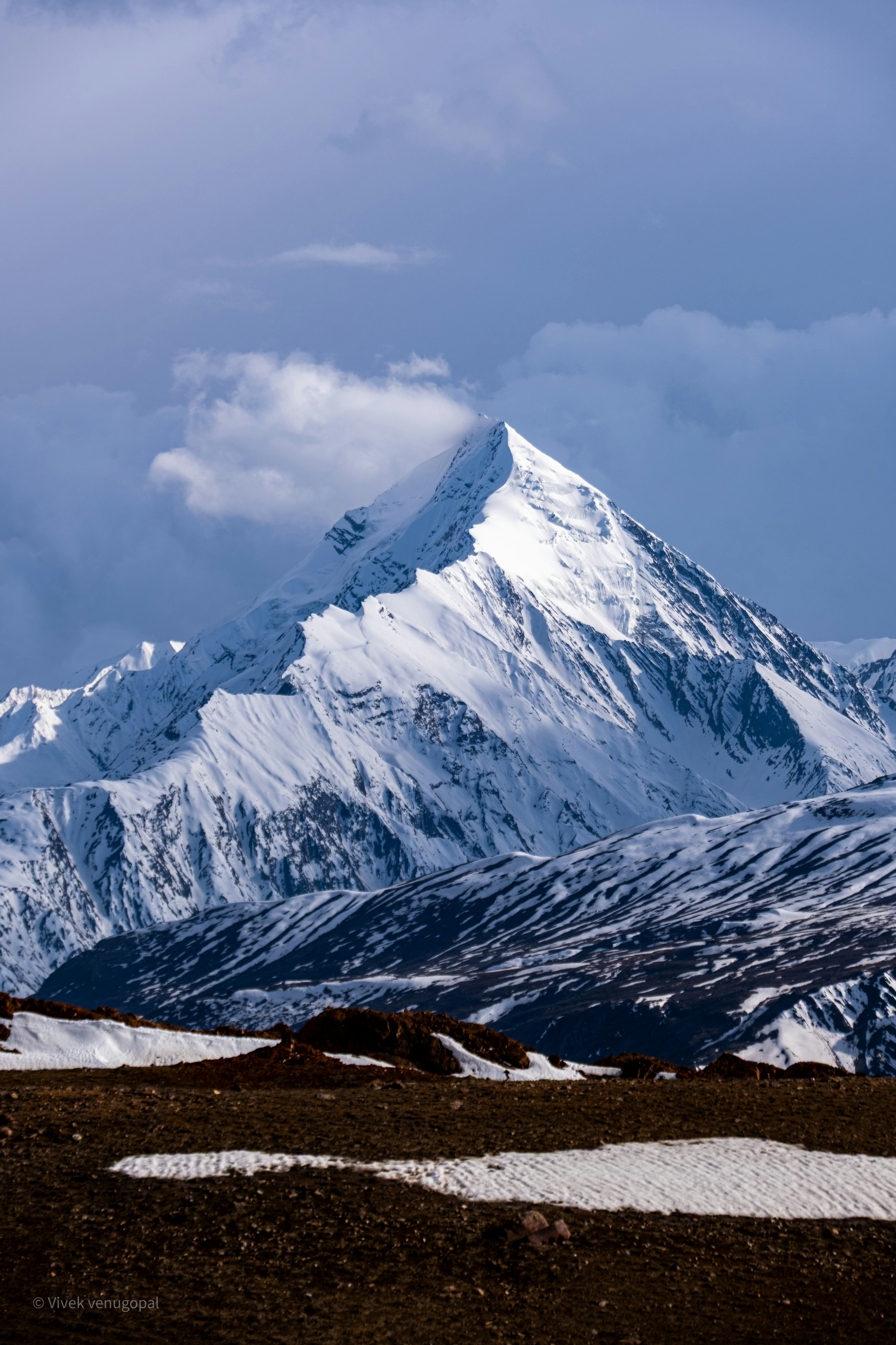 Snow-Crowned Peak Beneath a Crest of Clouds