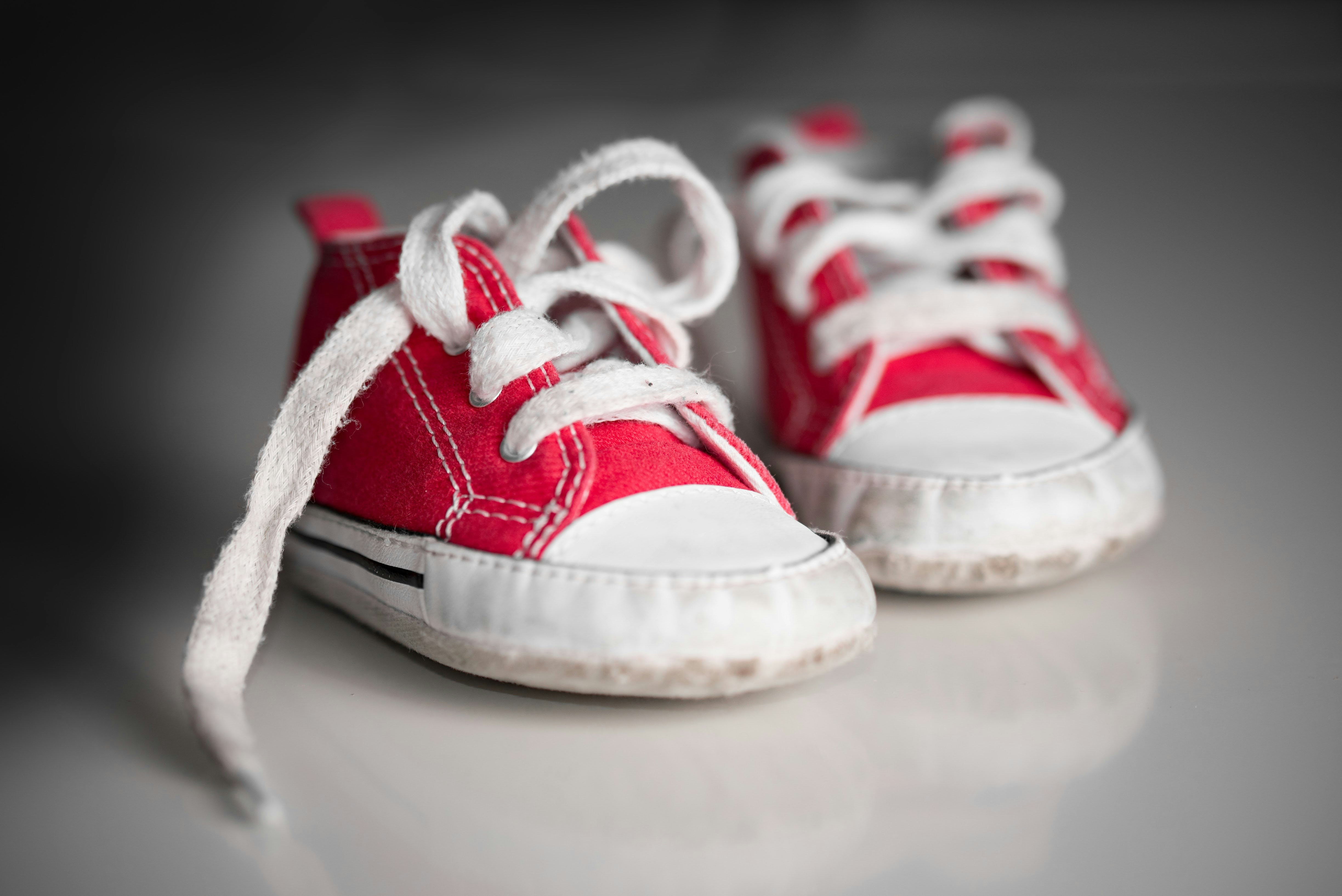 Red Sneakers on a Soft Spotlight: A Close curl of Footwear in Focus