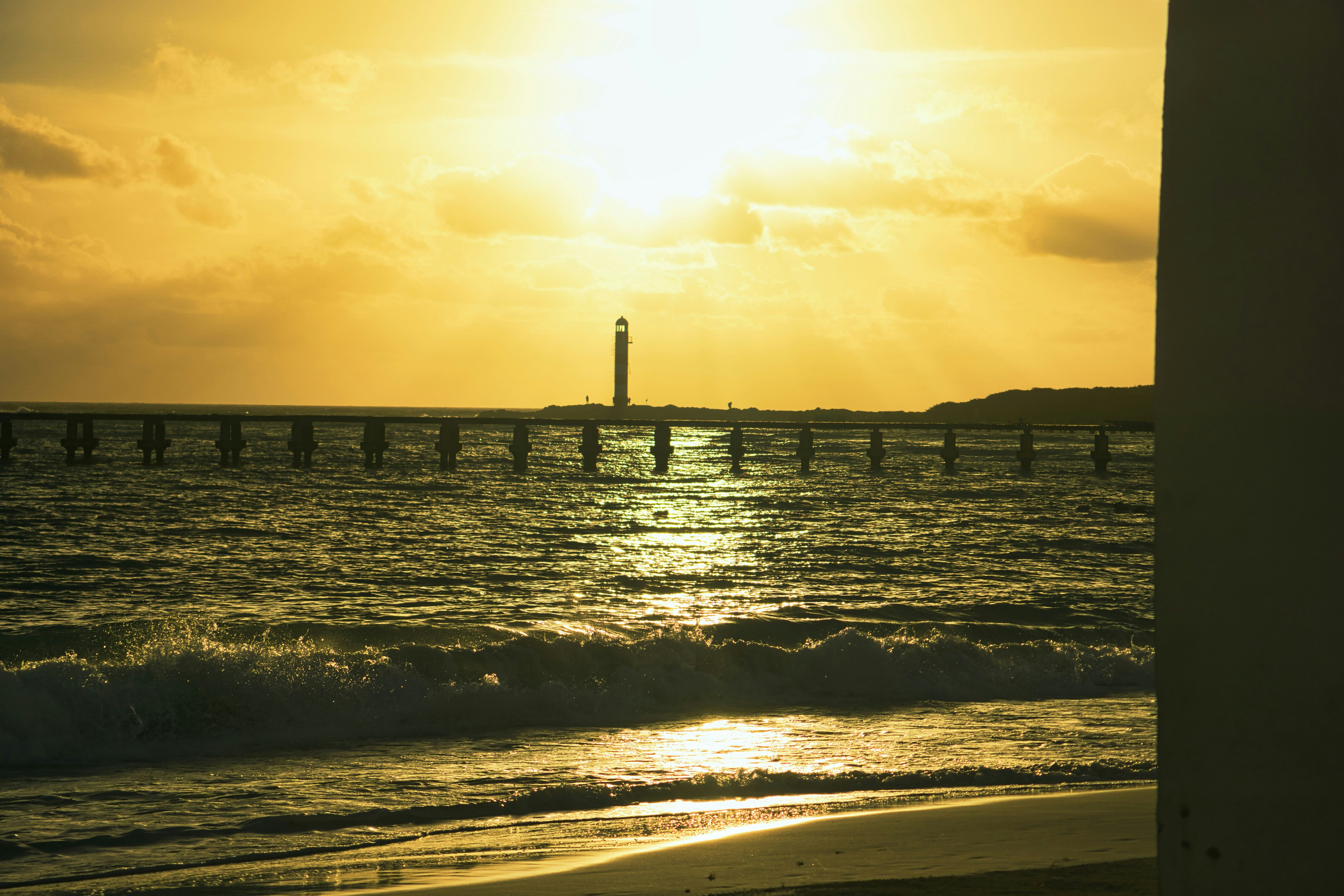 Golden Pier: Lighthouse Silhouette at Sunset