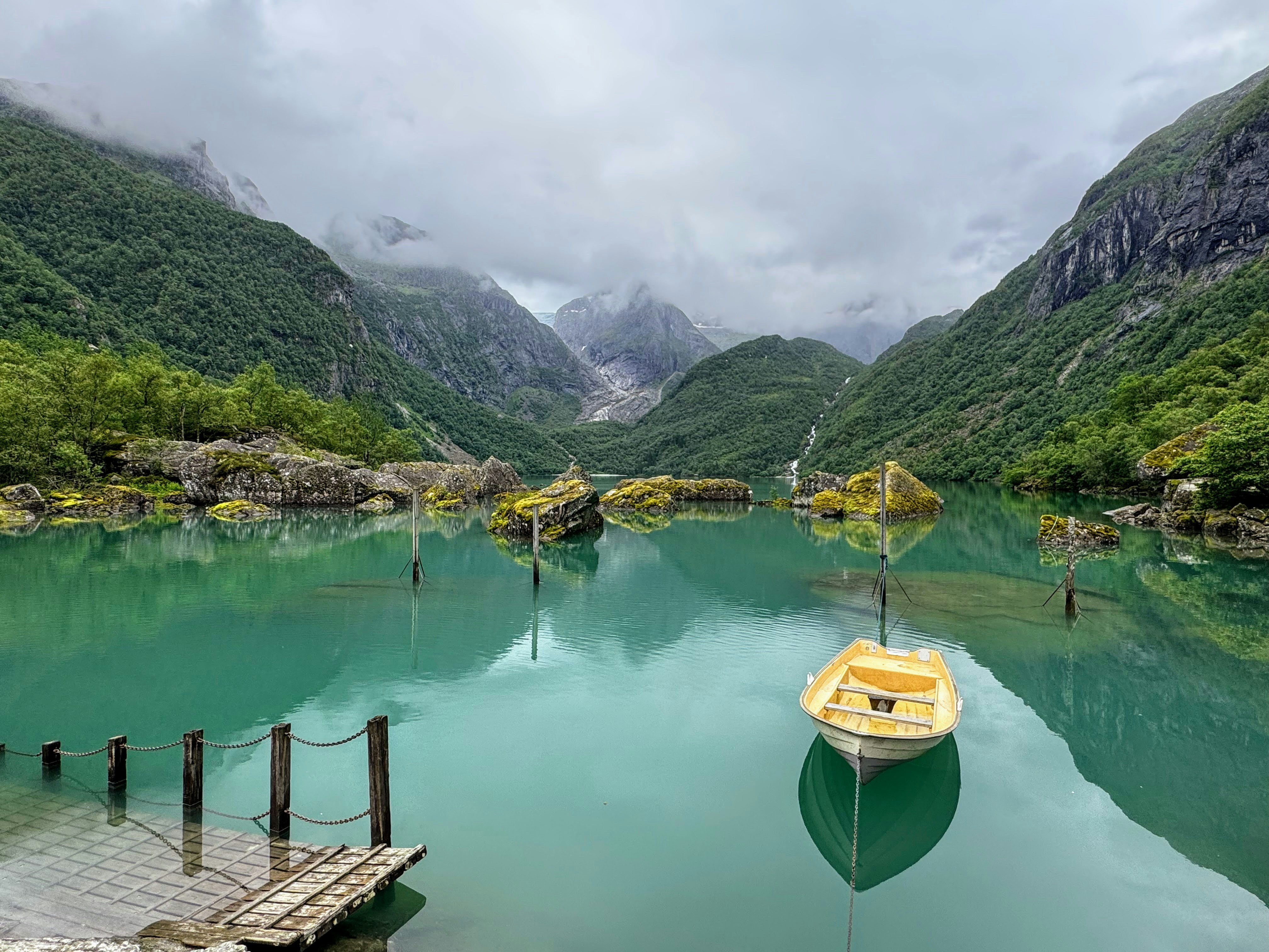 Emerald Mirror: A Lone Boat Anchored in Mountain Mist