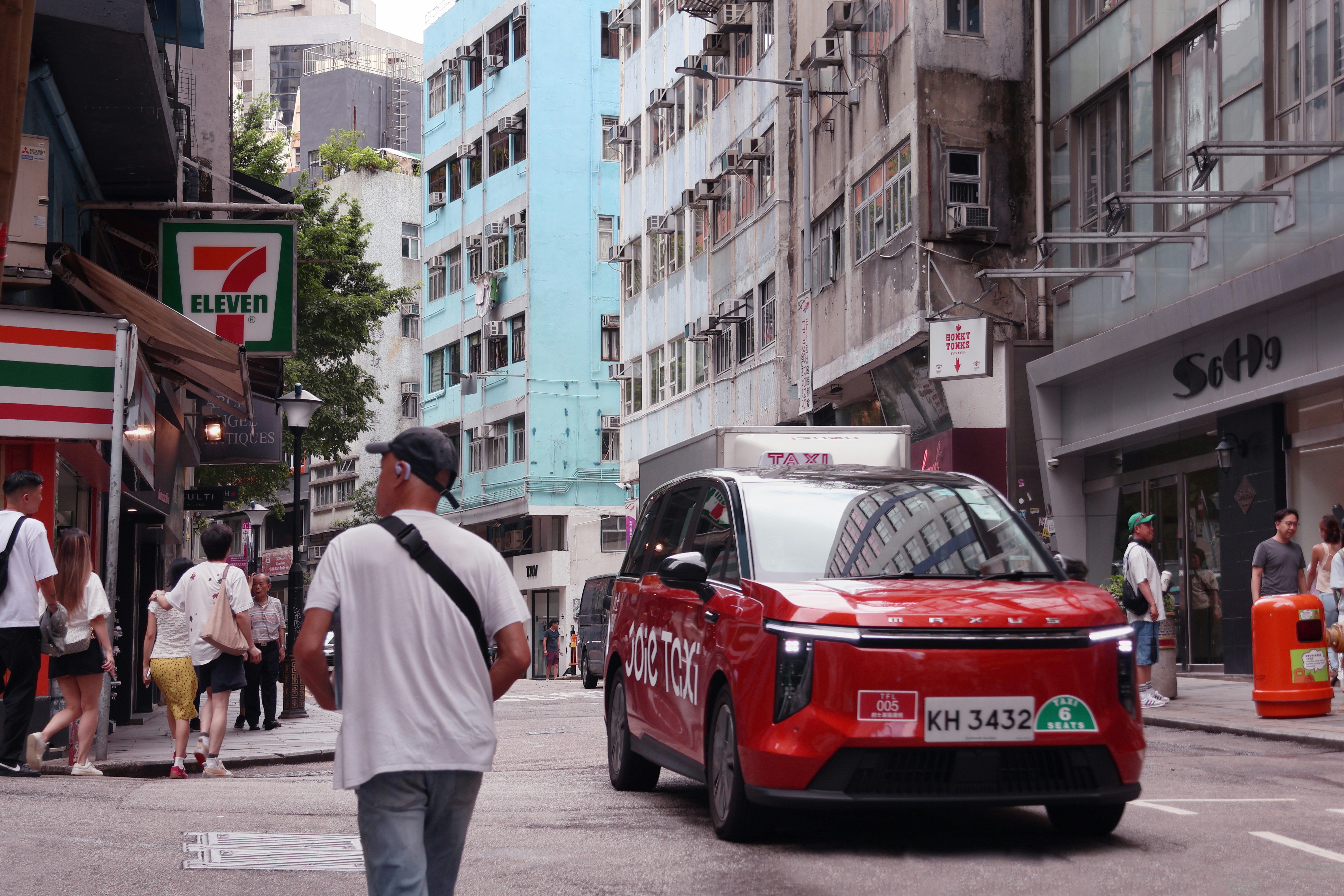 City Taxi Streak: A Red Courier in a Bustling Street