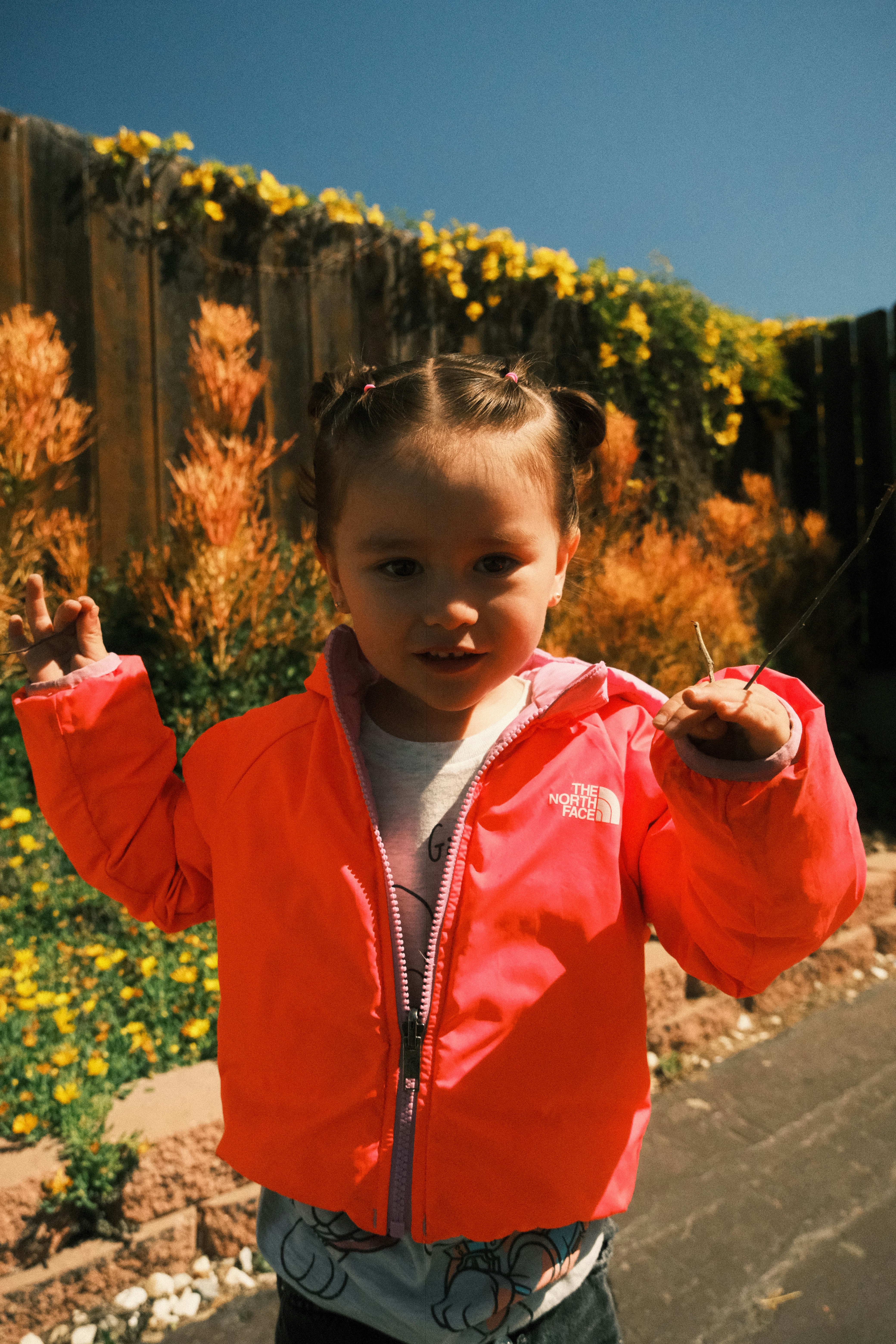 Bright Orange Teddy Jacket: A Little Explorer in a Sunny Garden