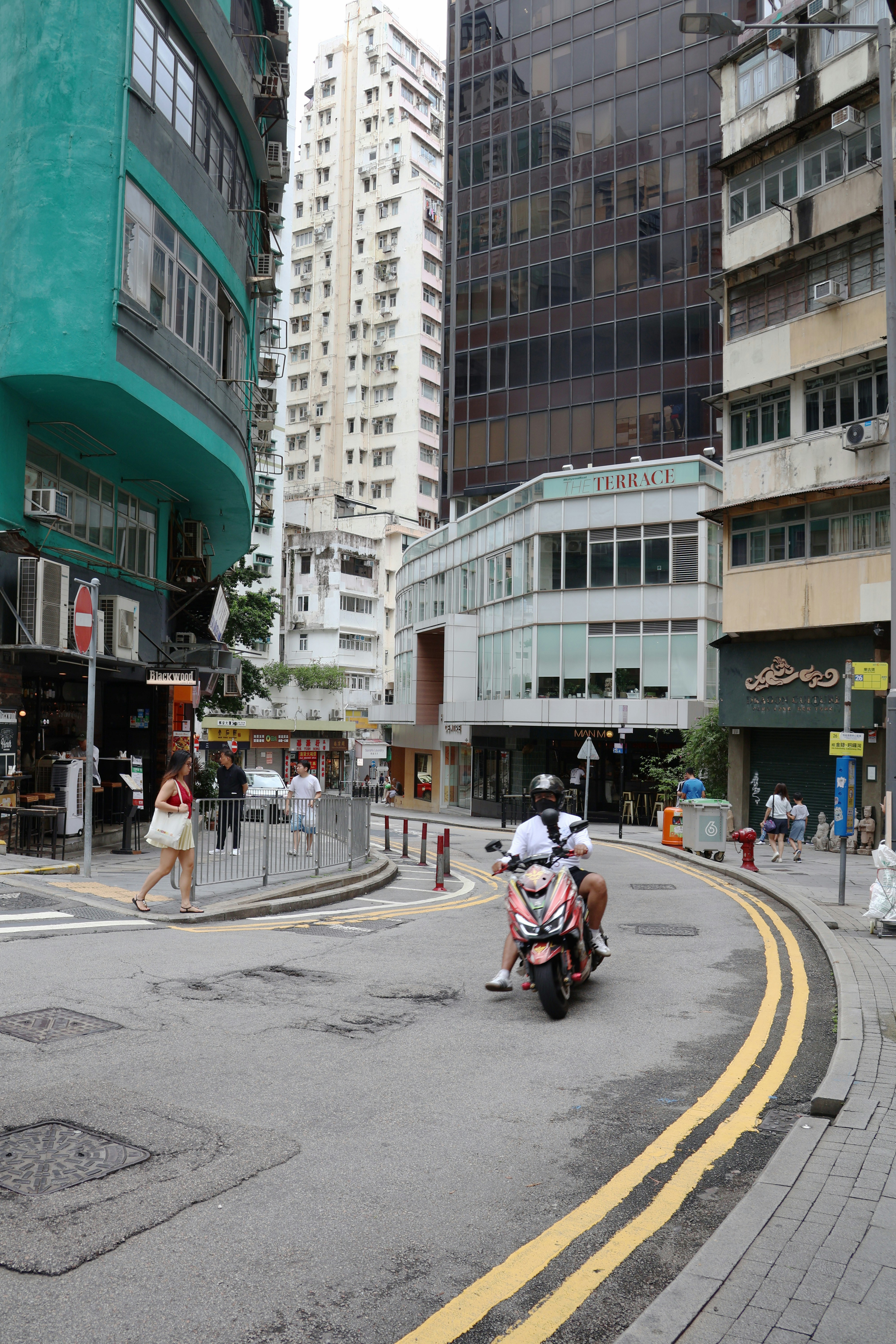 Street Curve: Motorbike Navigates a Busy Urban Corridor