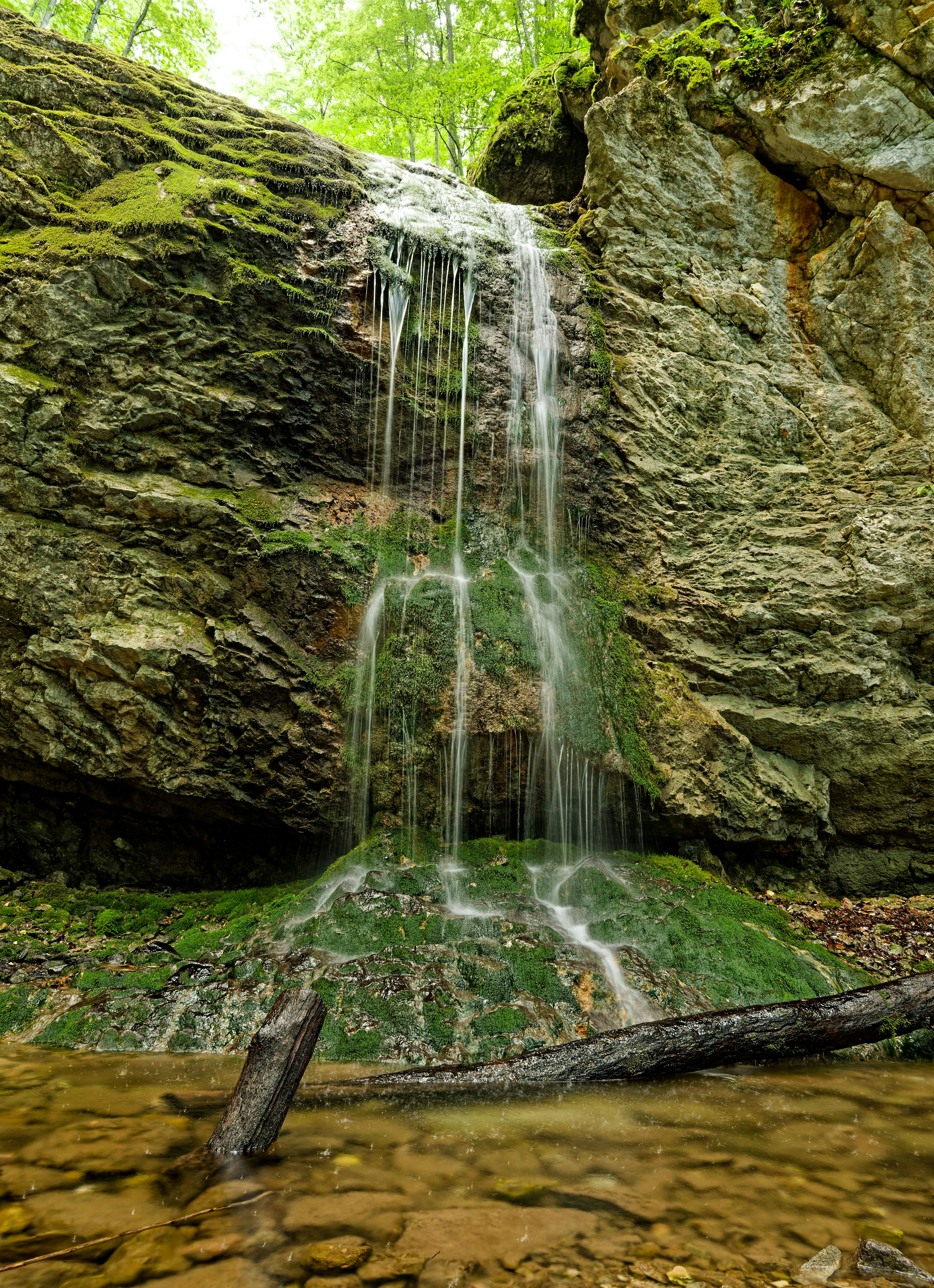 Moss-Cilled Cascade: A Hidden Waterfall Between Weathered Cliff Faces