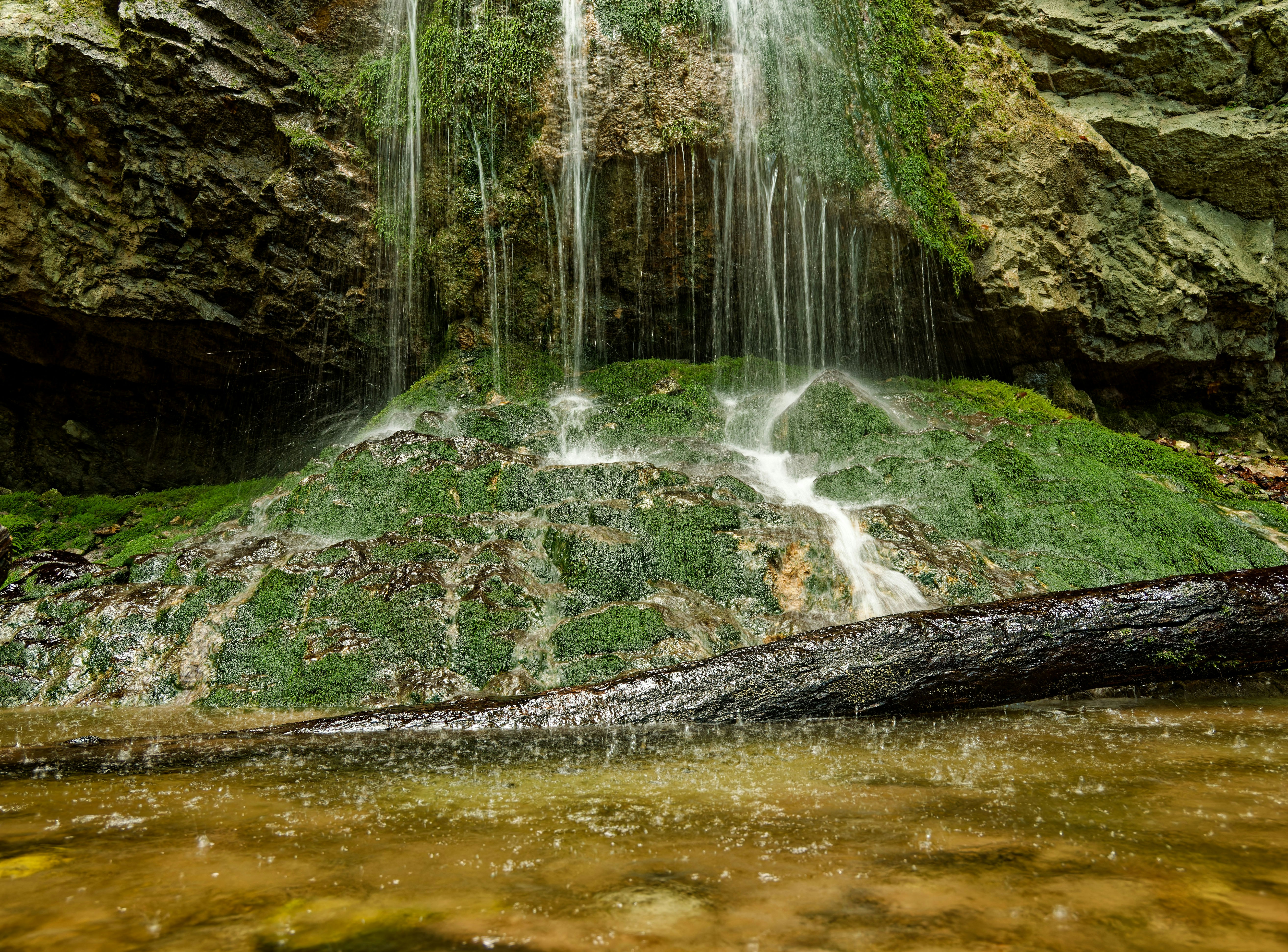 Mossy Cascade over Verdant Slopes Beneath Narrow Veils