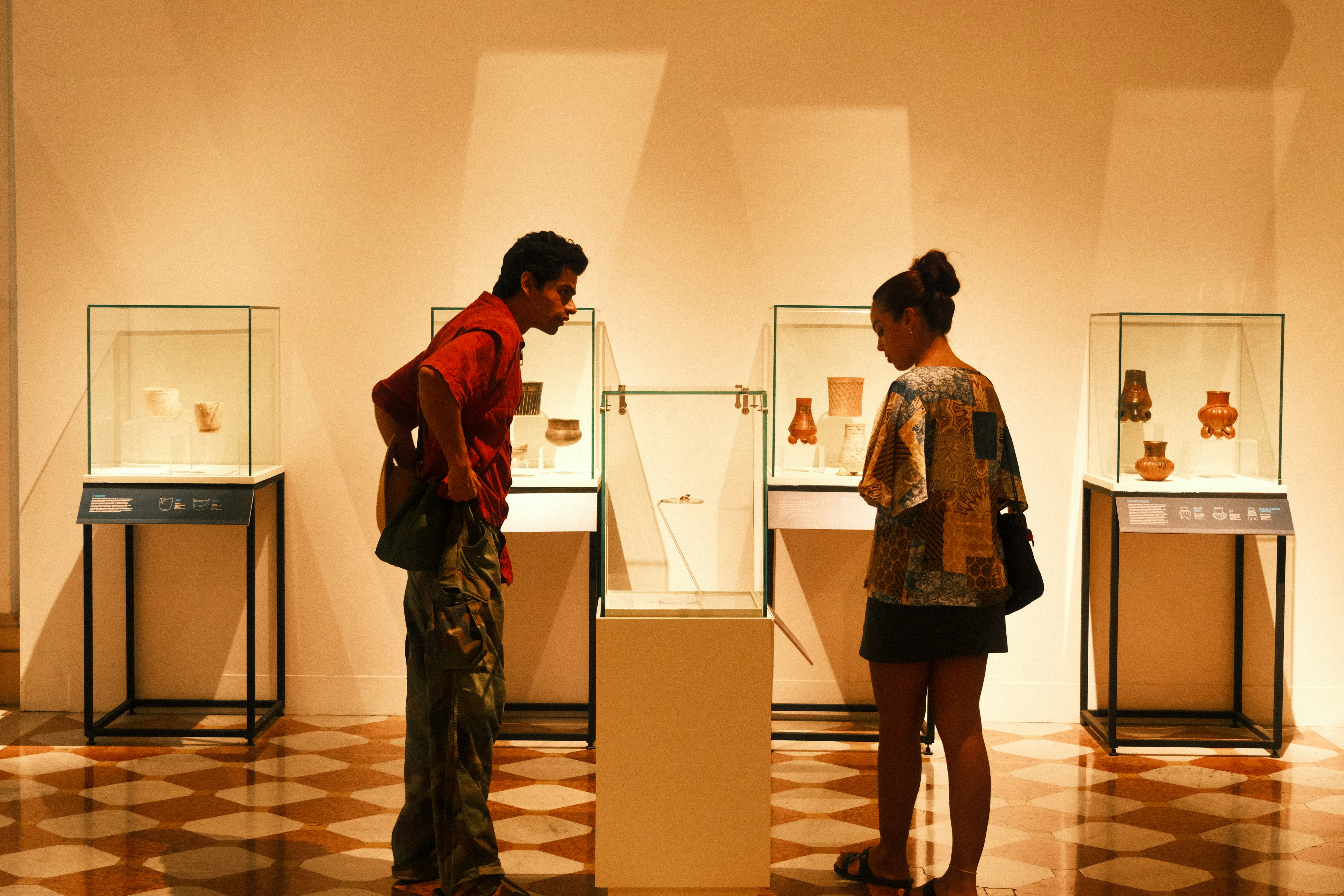 Museum Quiet: A Pair Admires an Exhibit Under Warm Gallery Light