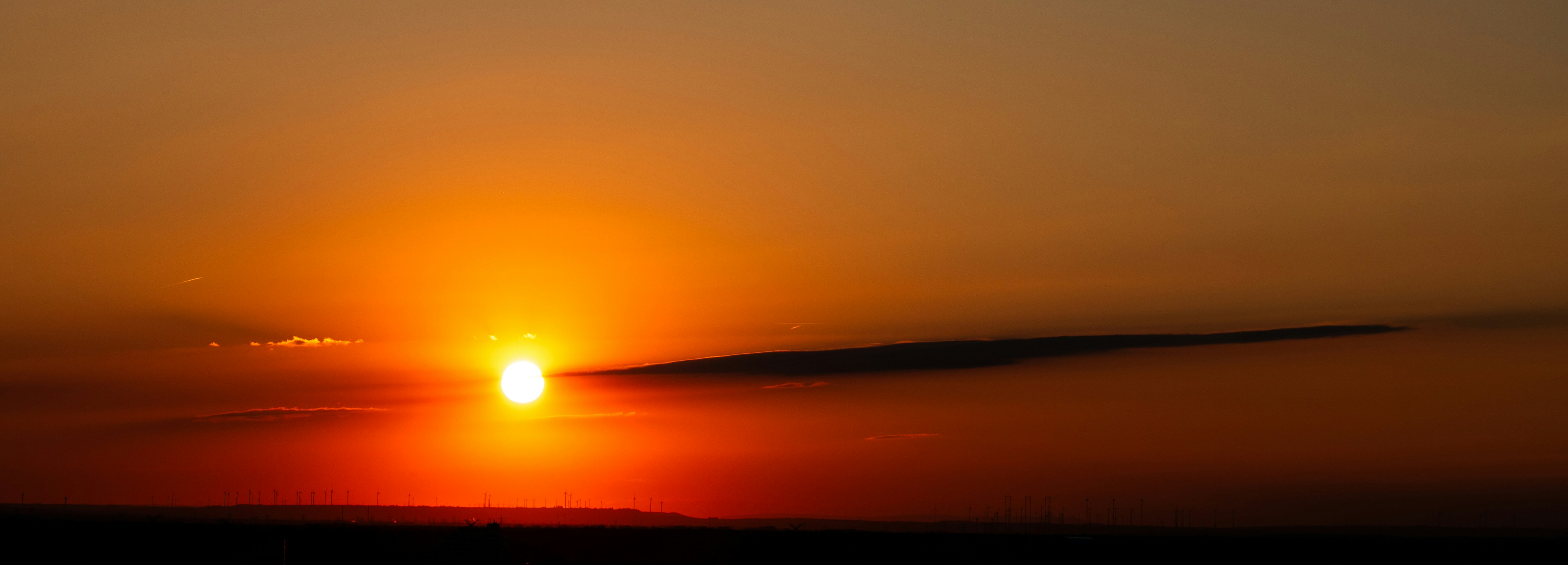 Quiet Horizon: The Glowing Sun at Dusk Over a Flat Calm Sea