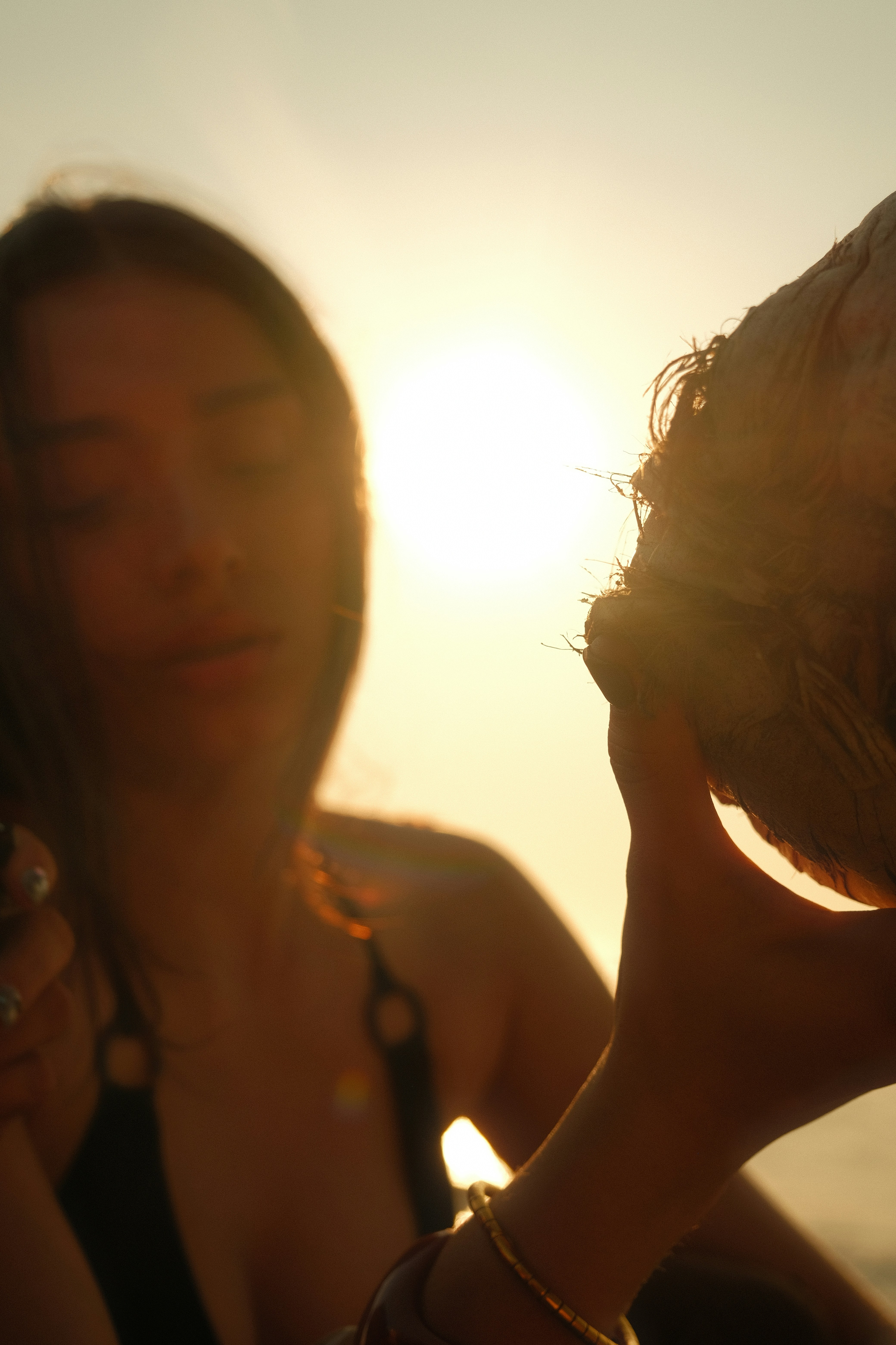 Sunlit Moment: Close-Up of a Handheld Shell Against Backlit Portrait