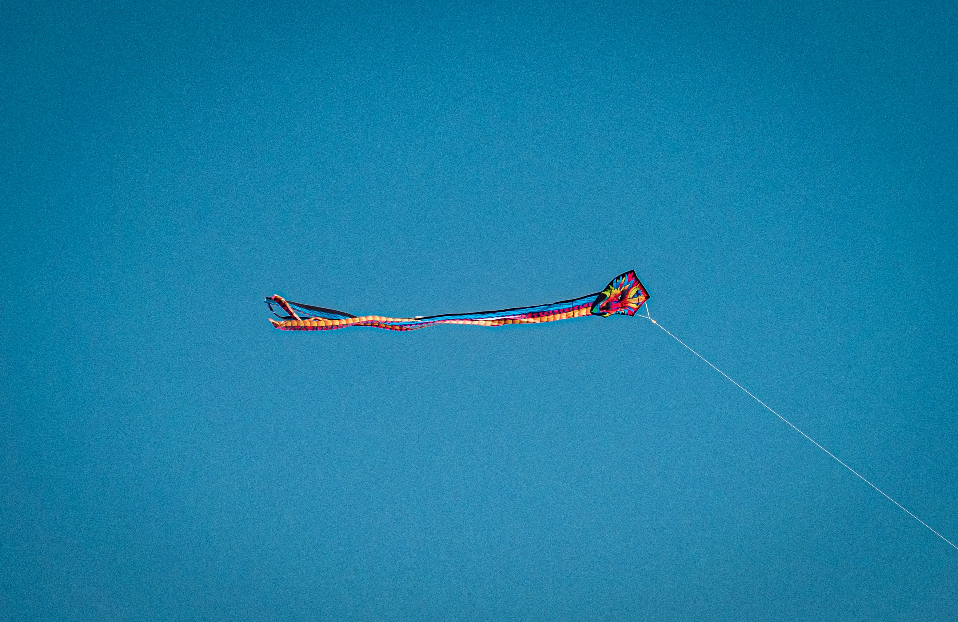 Single kite dancing on a clear blue sky
