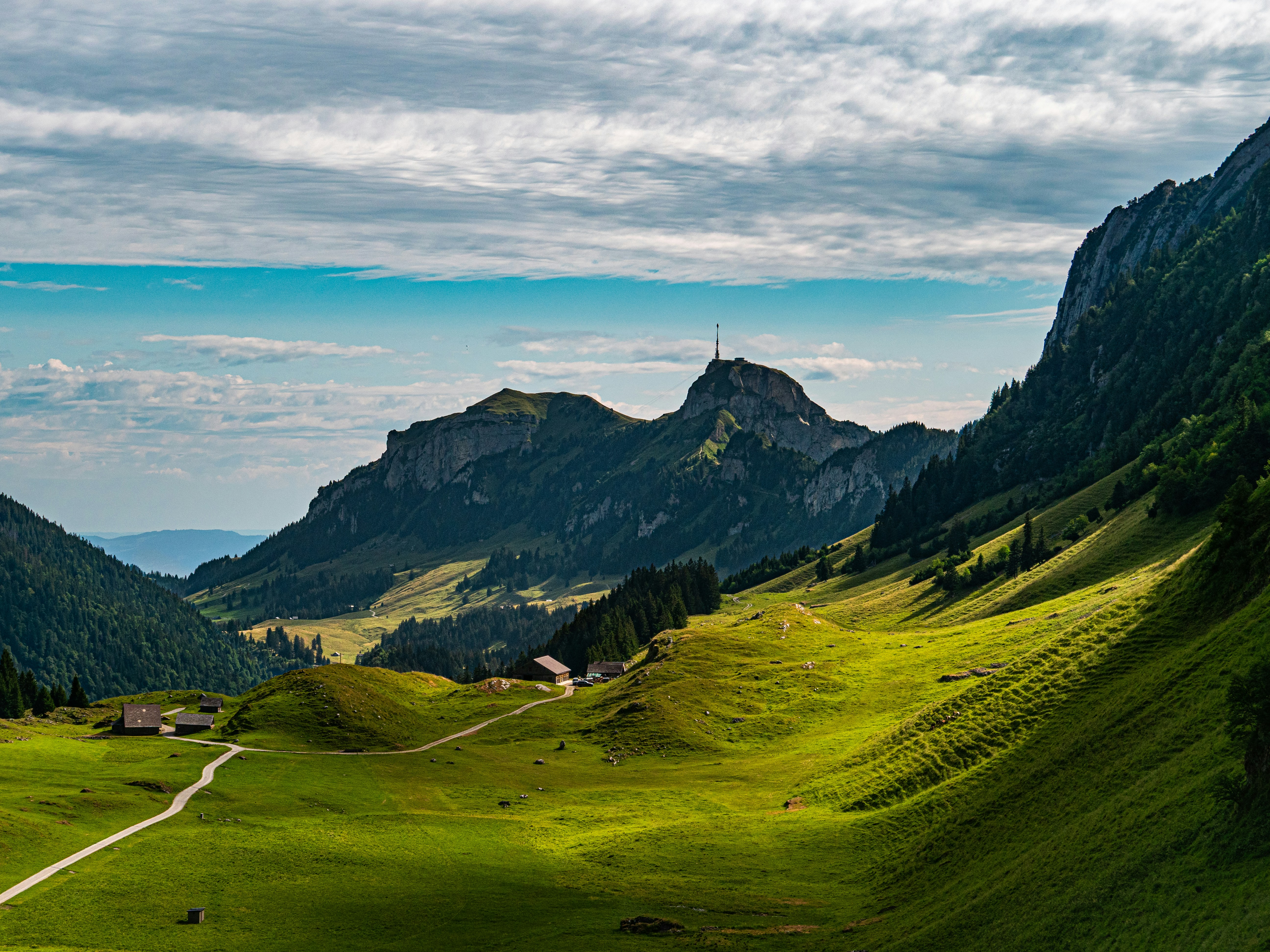 Sunlit Saddle: A Verdant Valley Under Alpine Peaks