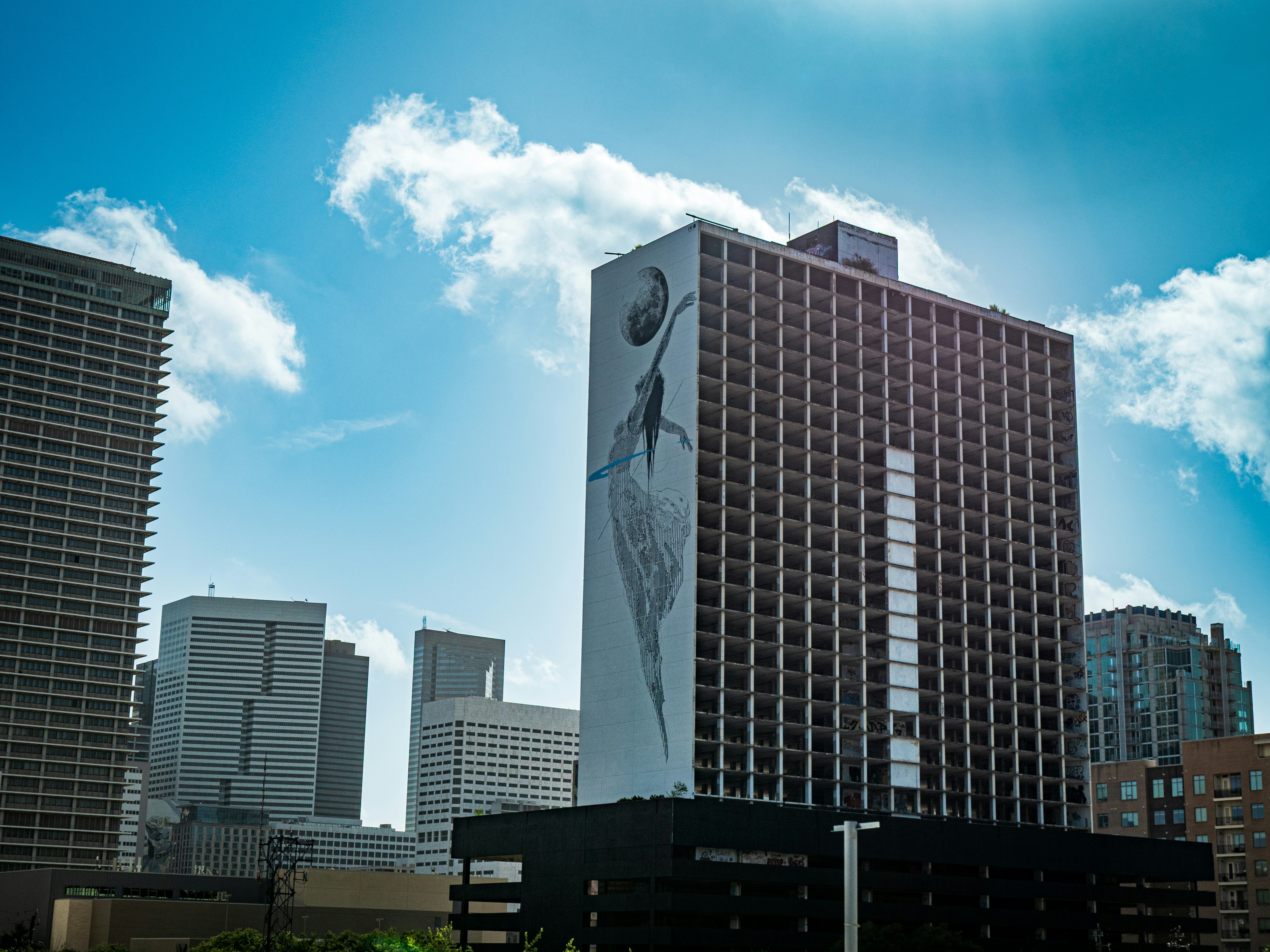 Tower Portrait: A Glassy Skyline Beside a Painted Giant