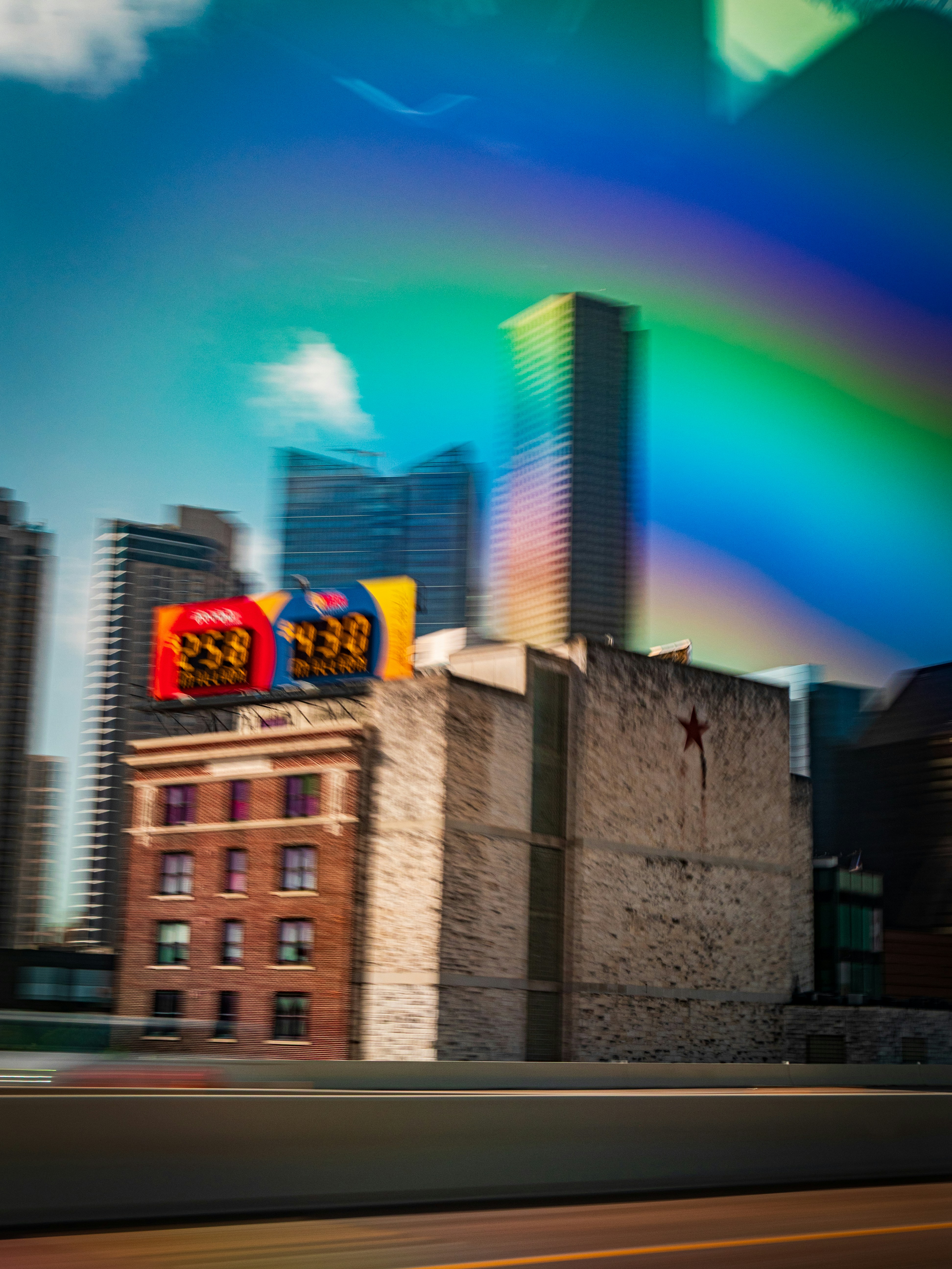 Rainbow arc over downtown: blurred motion and neon signage