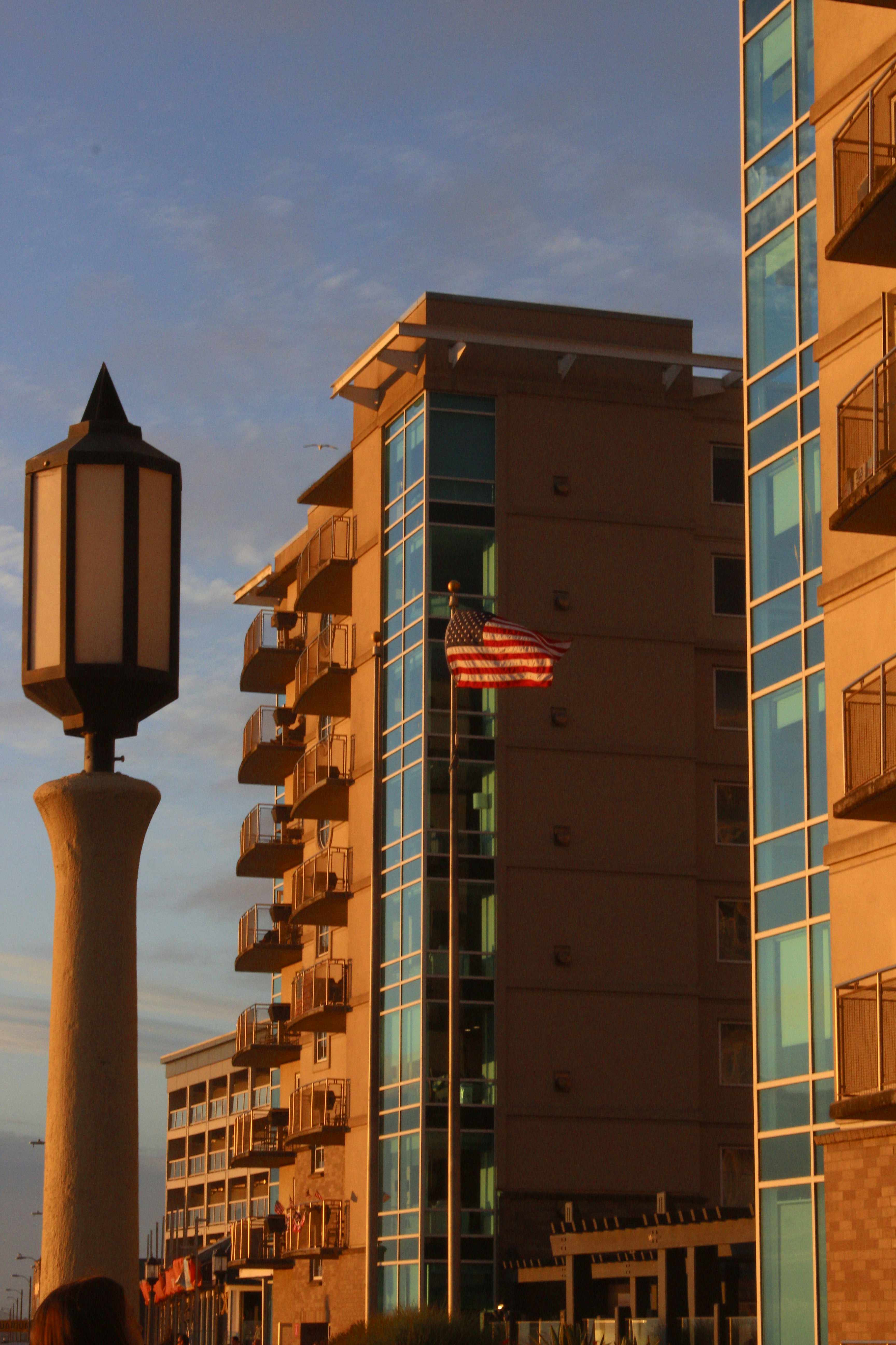 Sunlit Urban Beacon: American Flag Adorns a Modern Balcony