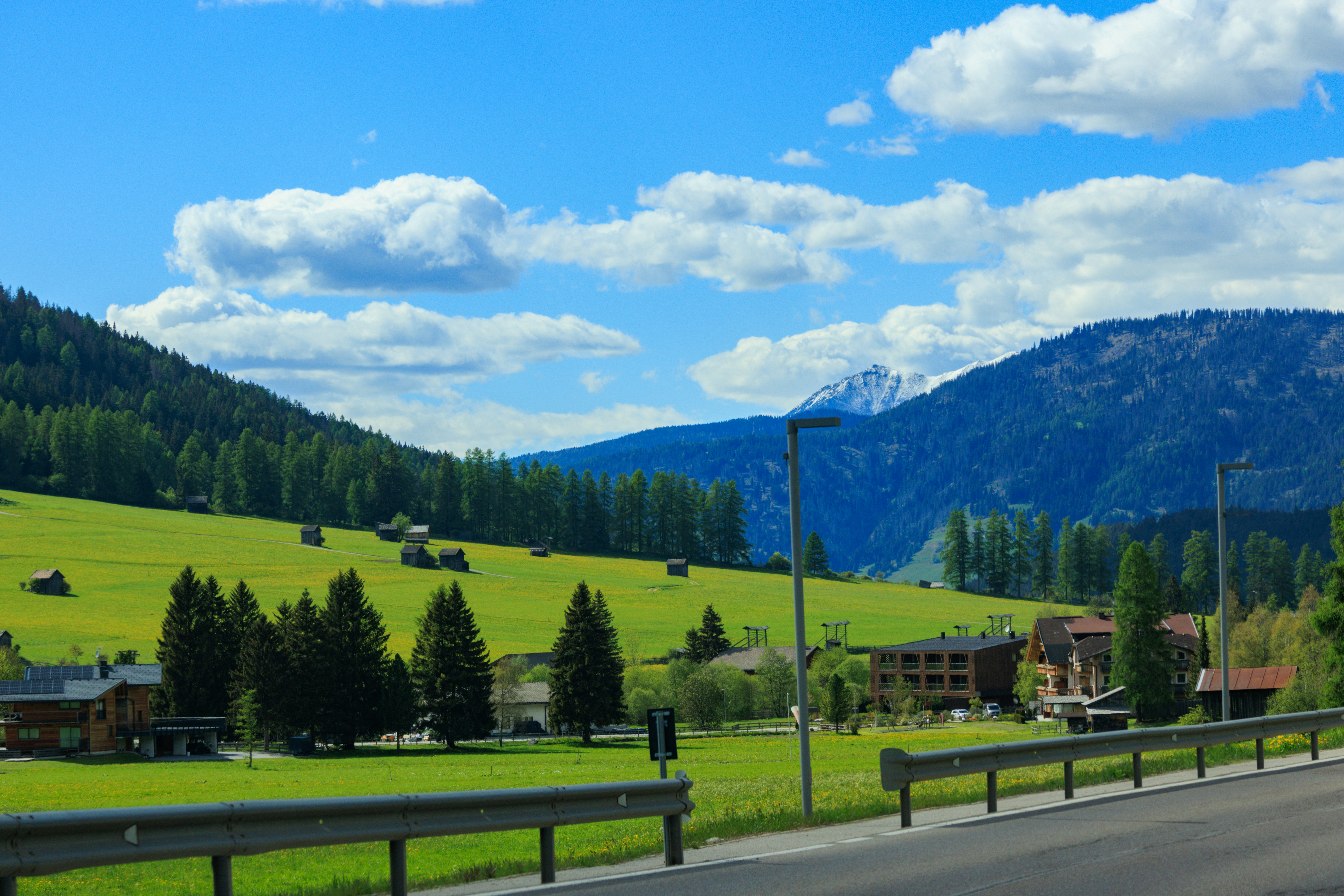 Sunlit Valley Roadway Beneath Snow-kissed Peaks