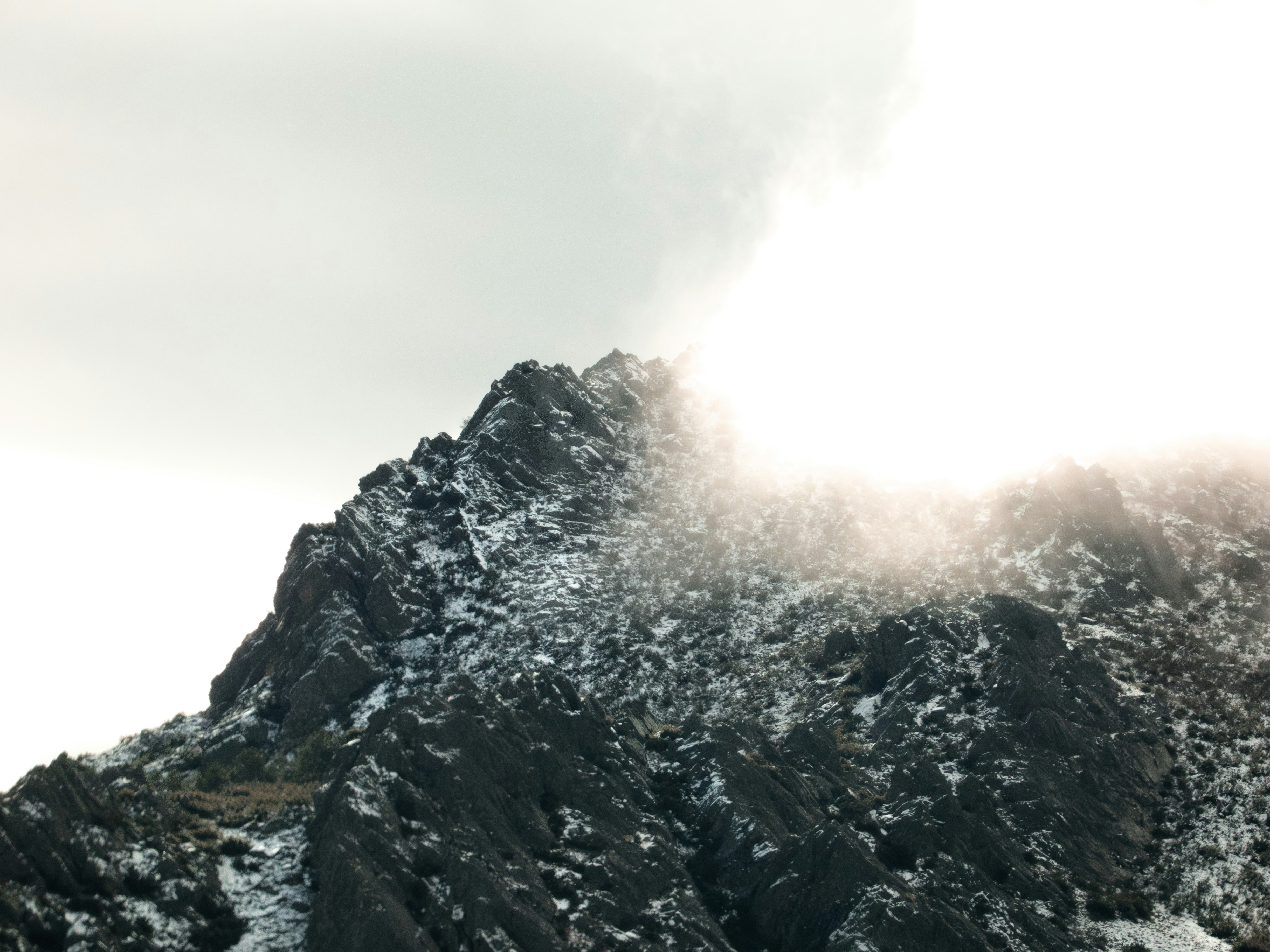Snow-kissed Peak Emerging Through Bright Alpine Light