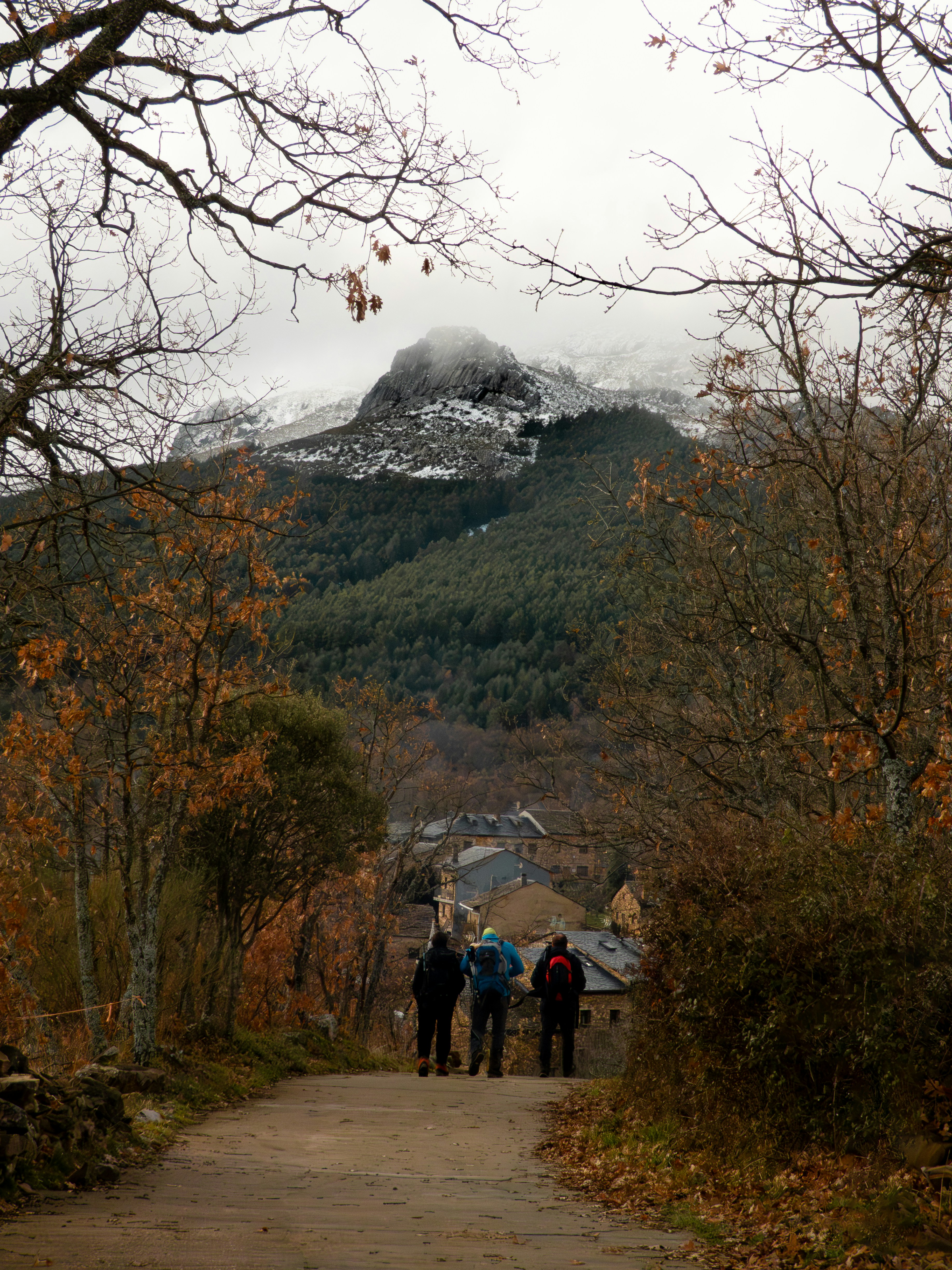 Hikers Descent Toward a Snow-dusted Peak