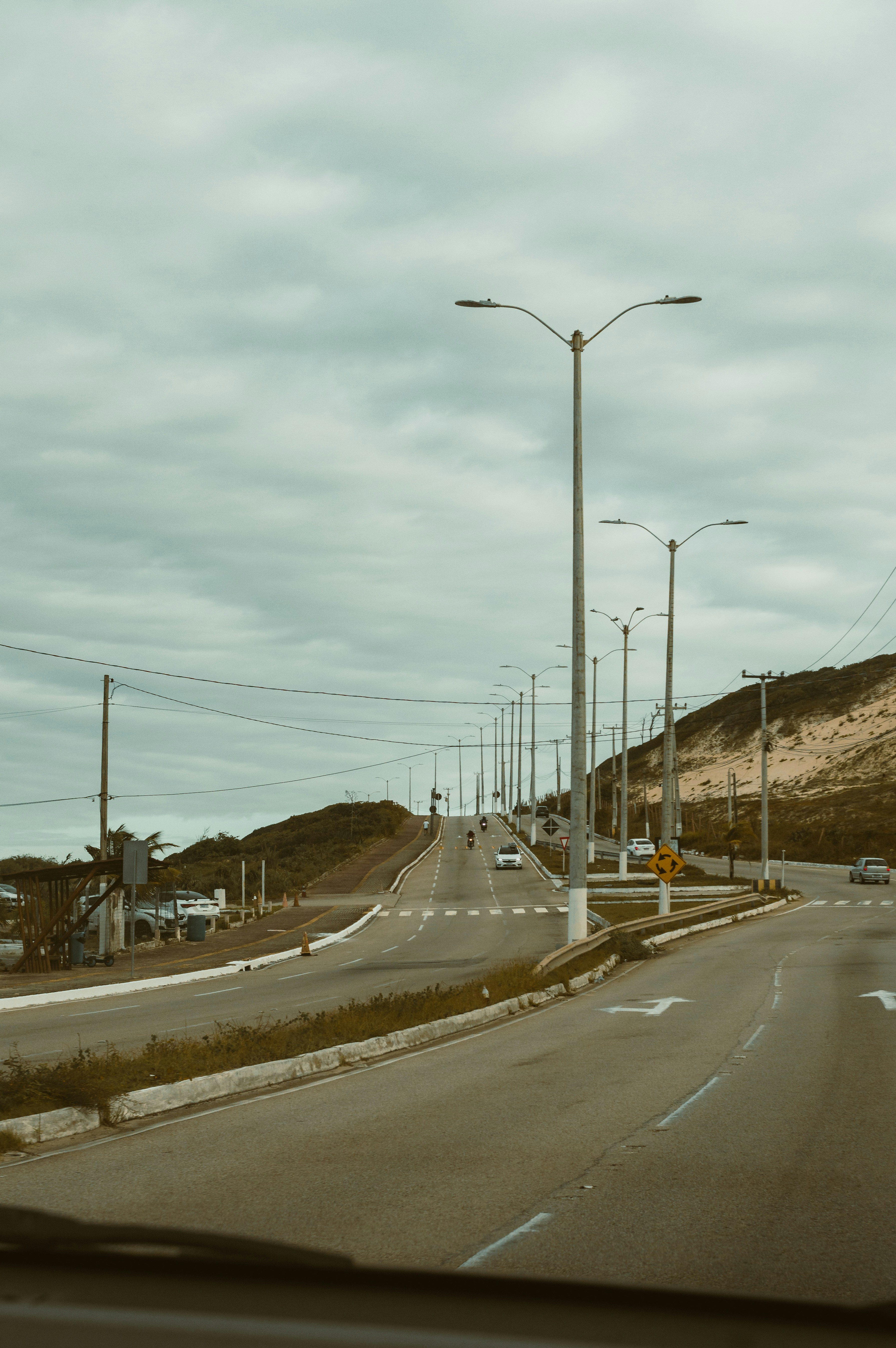 A Quiet Descent: Streetlights Line a Winding Coastal Road
