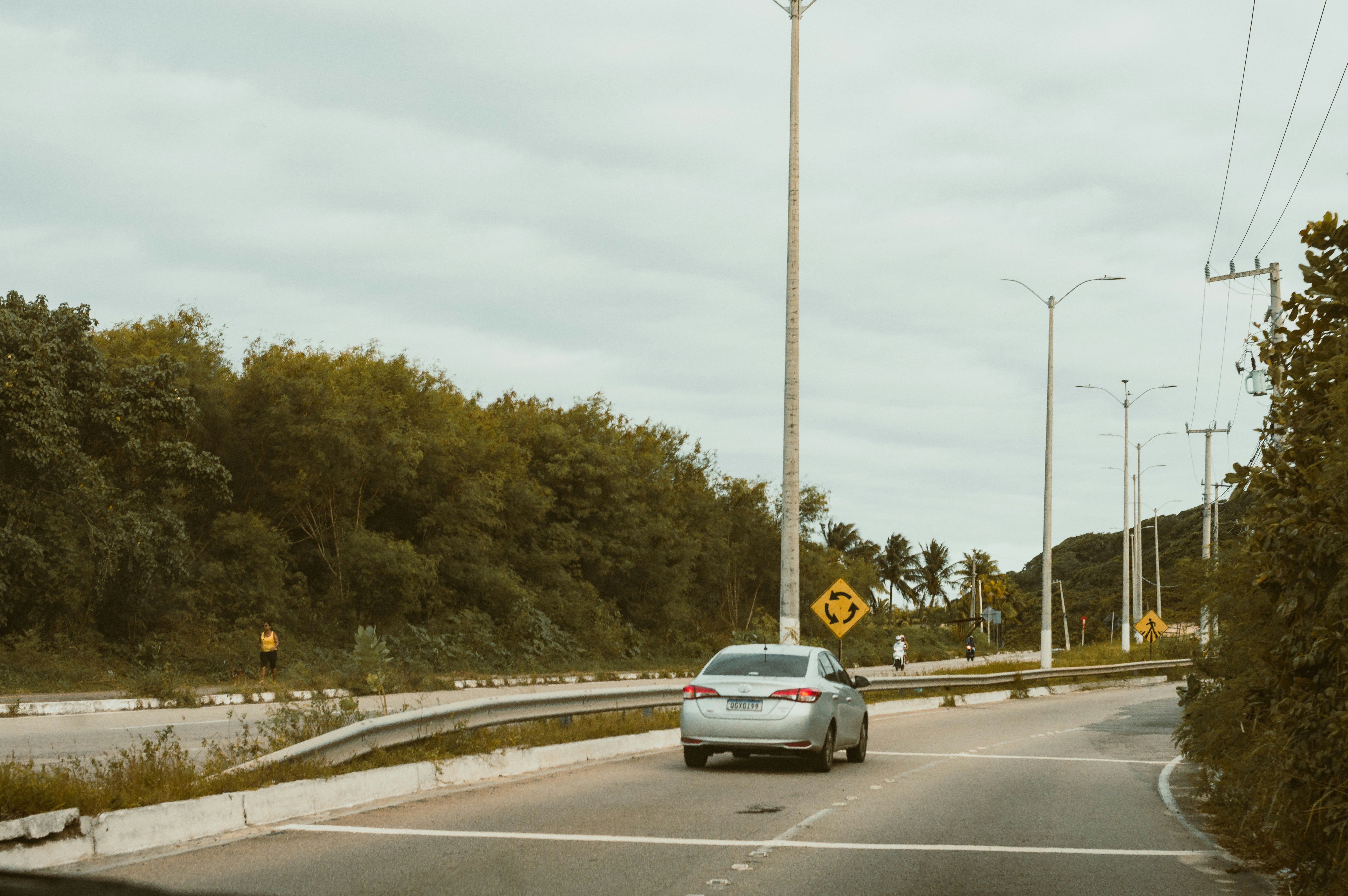 Roadside Signal: Car on a Winding Highway Approaching a Caution Bend