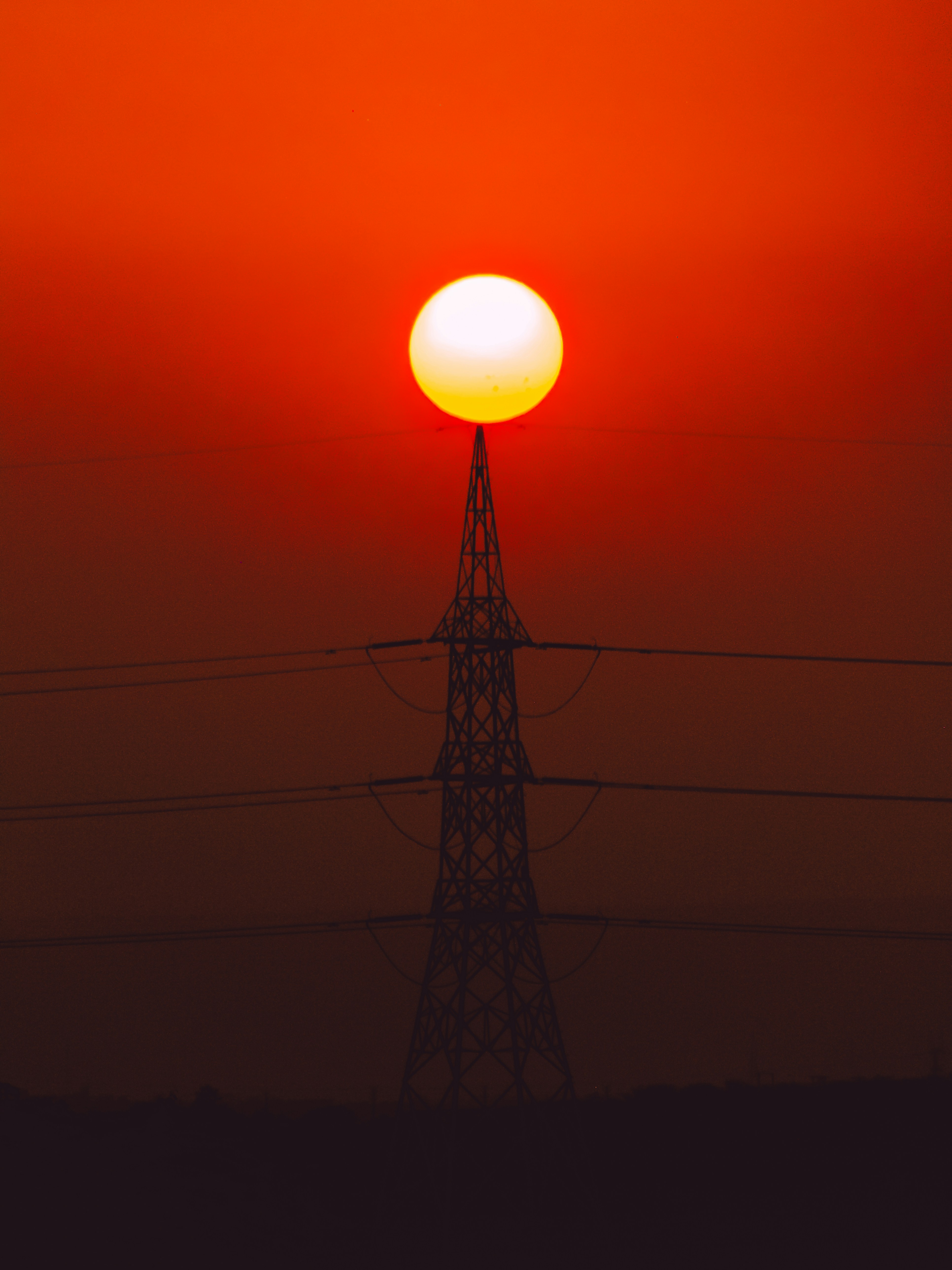 Sunset on the Tower: A Radiant Sphere Crowned by Power Lines