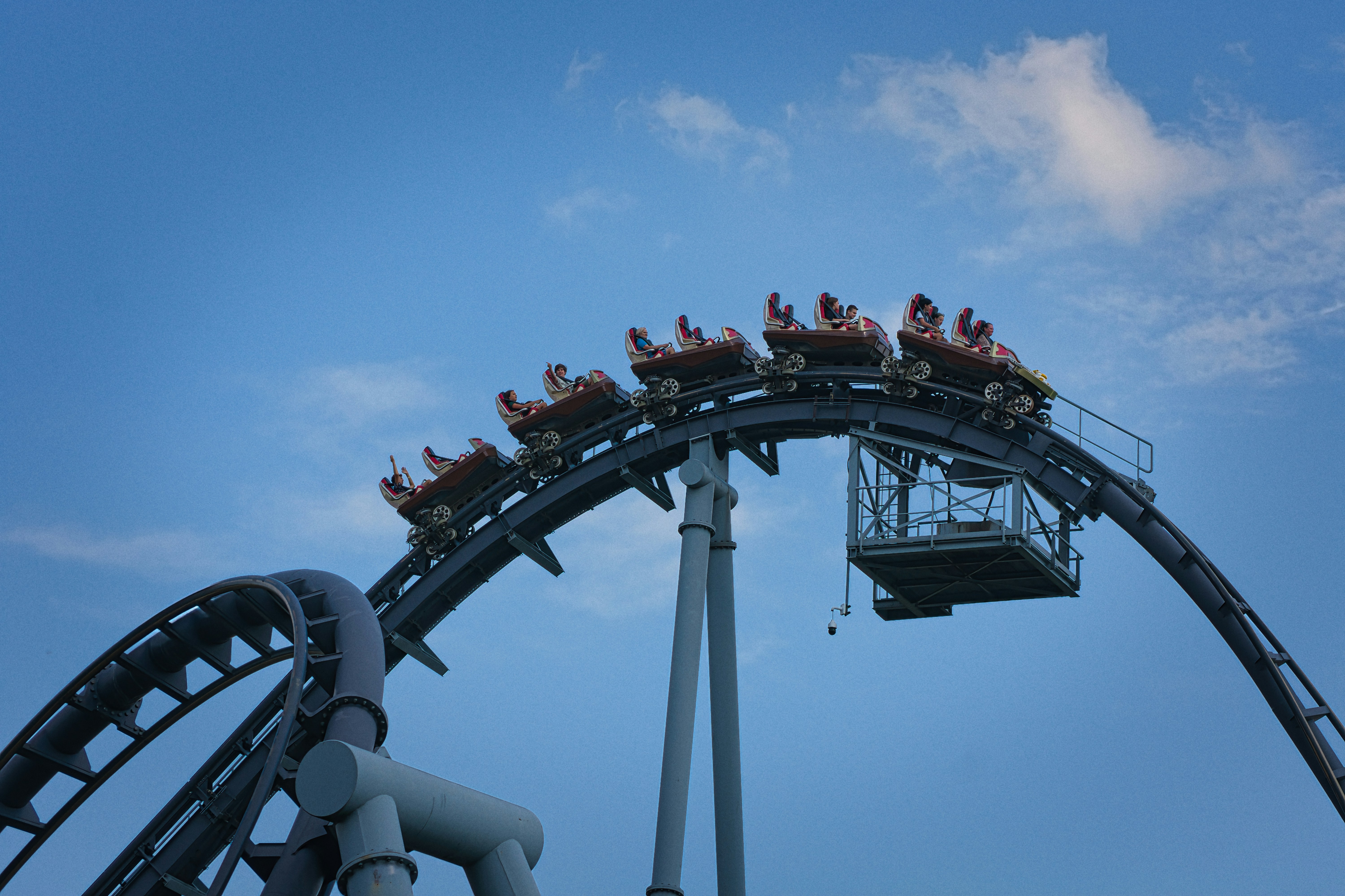 A Loop of Grit and Glee: Riders Crest the Crest of a Roller Coaster