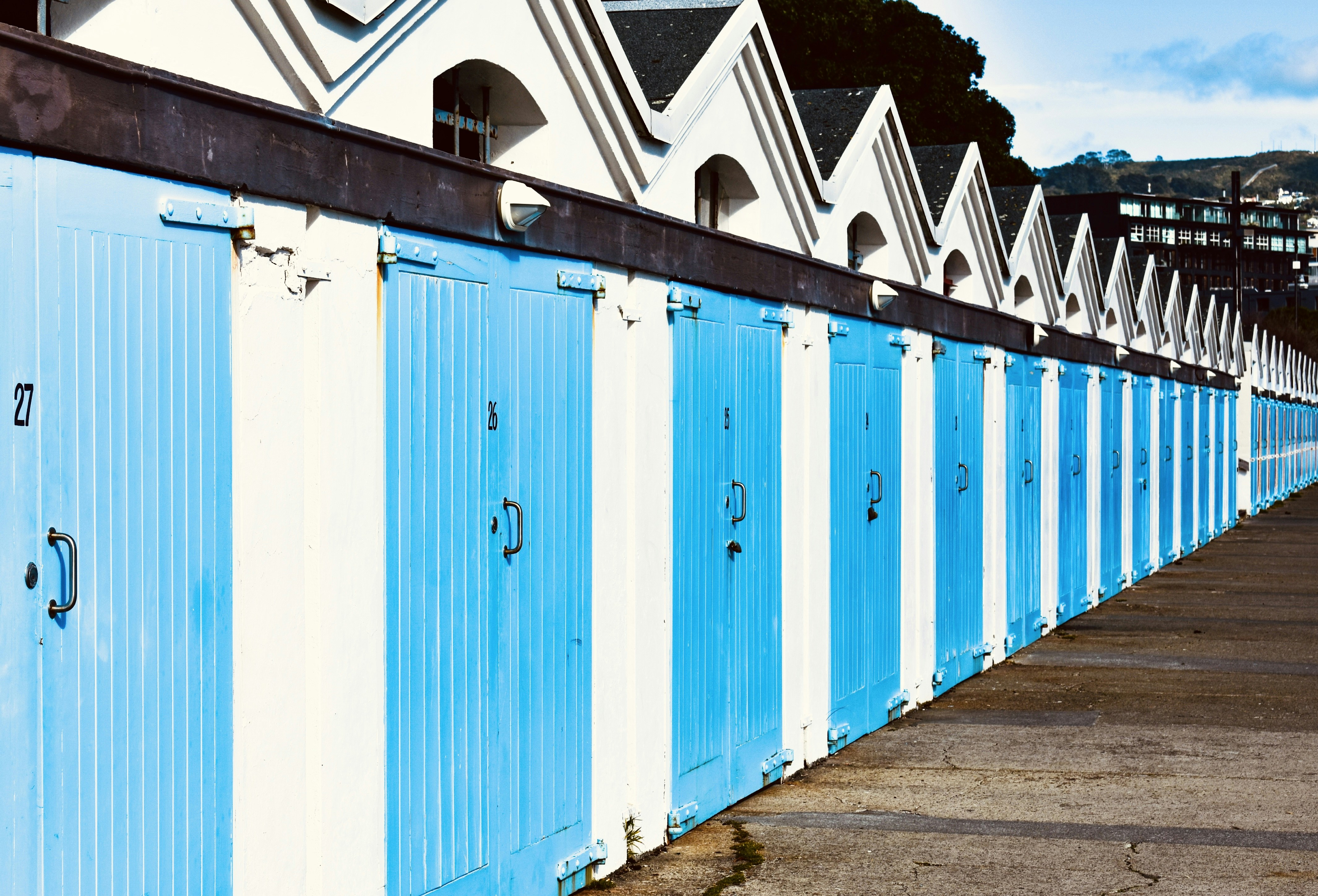 Row of Azure Beach Lockers Under a Sunlit Crest