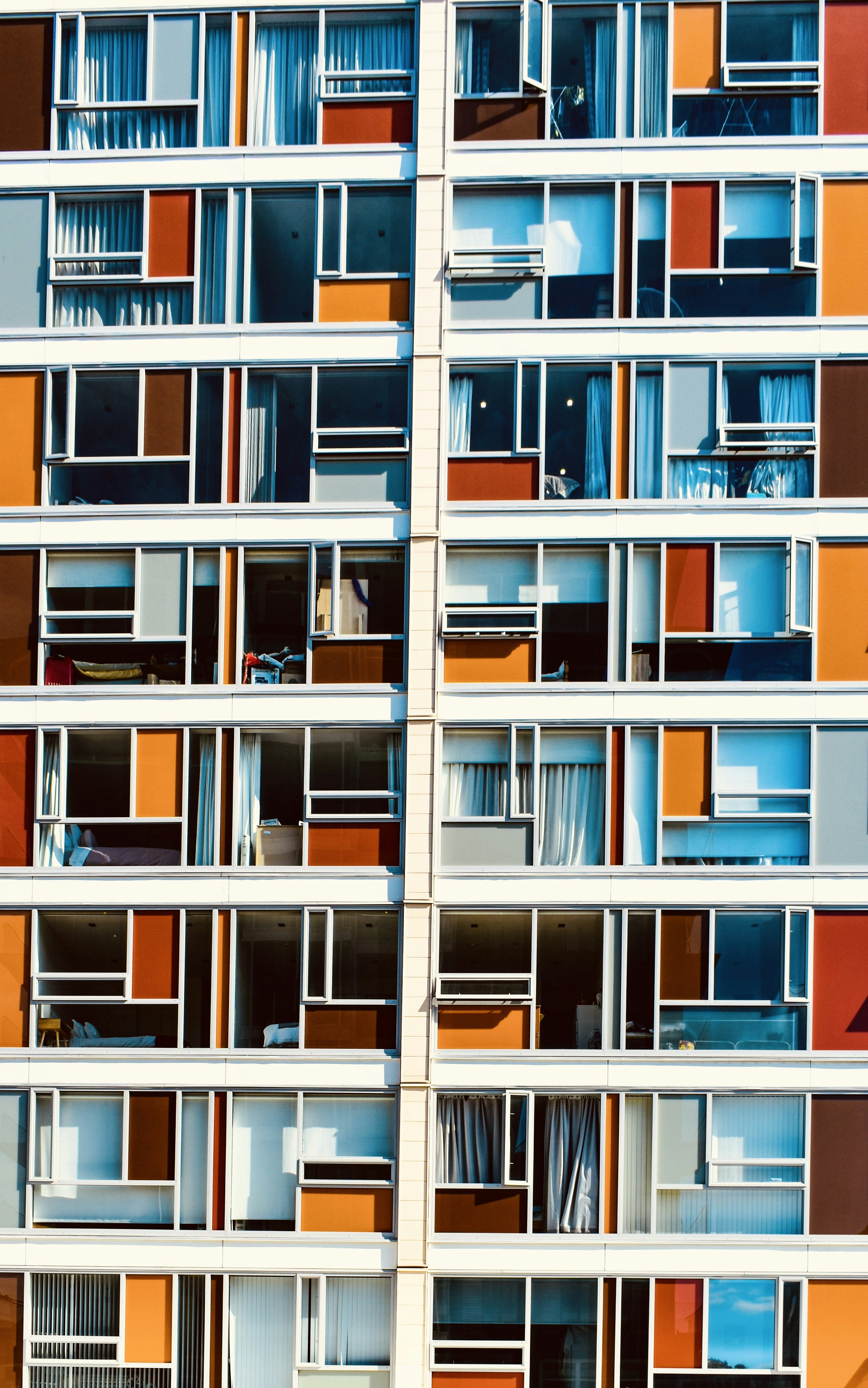Chromatic Block Facade: A Grid of Colored Windows Transformed by Light and Shadow