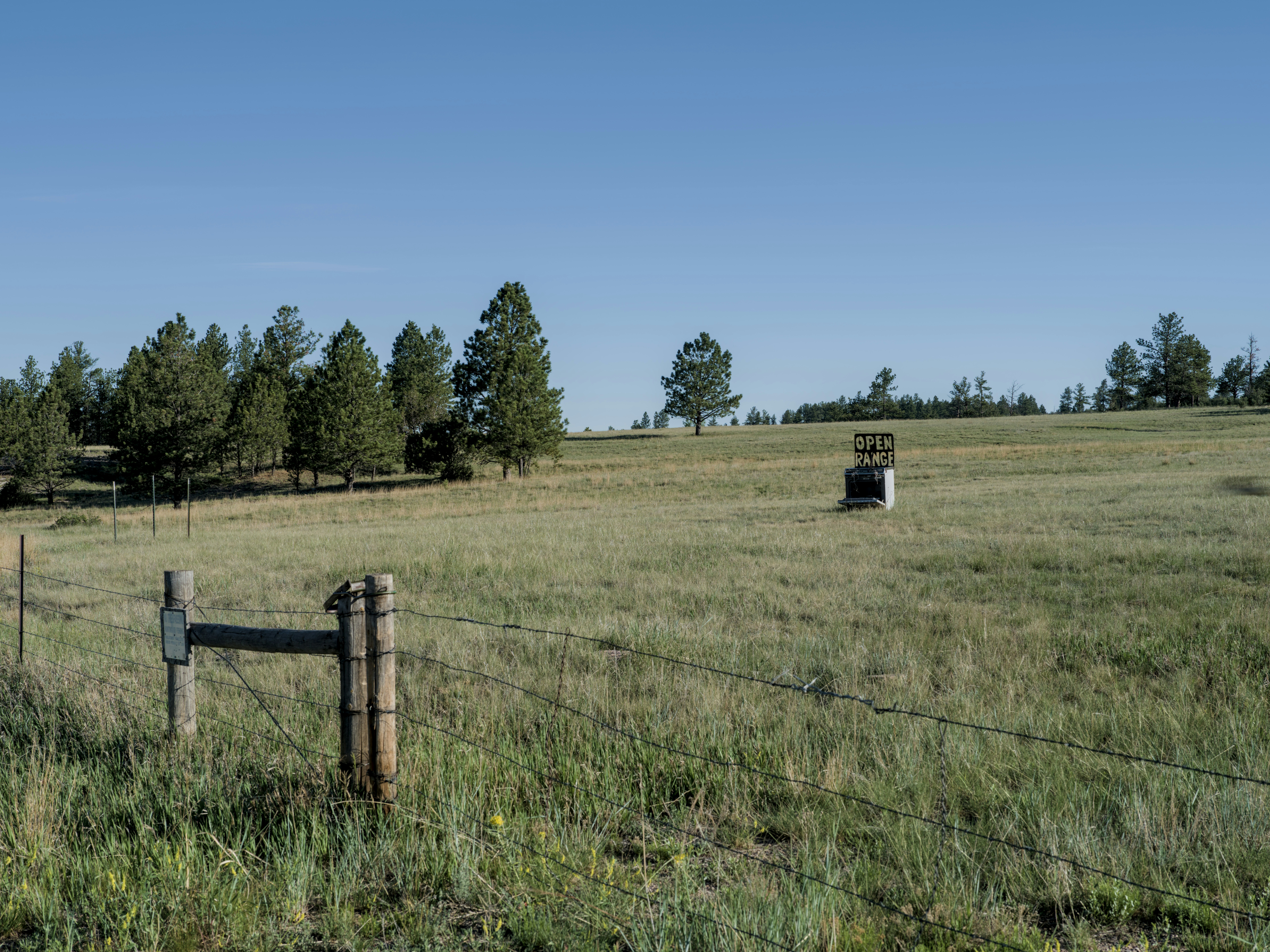 Fence line toward a distant acoustic field under a clear sky