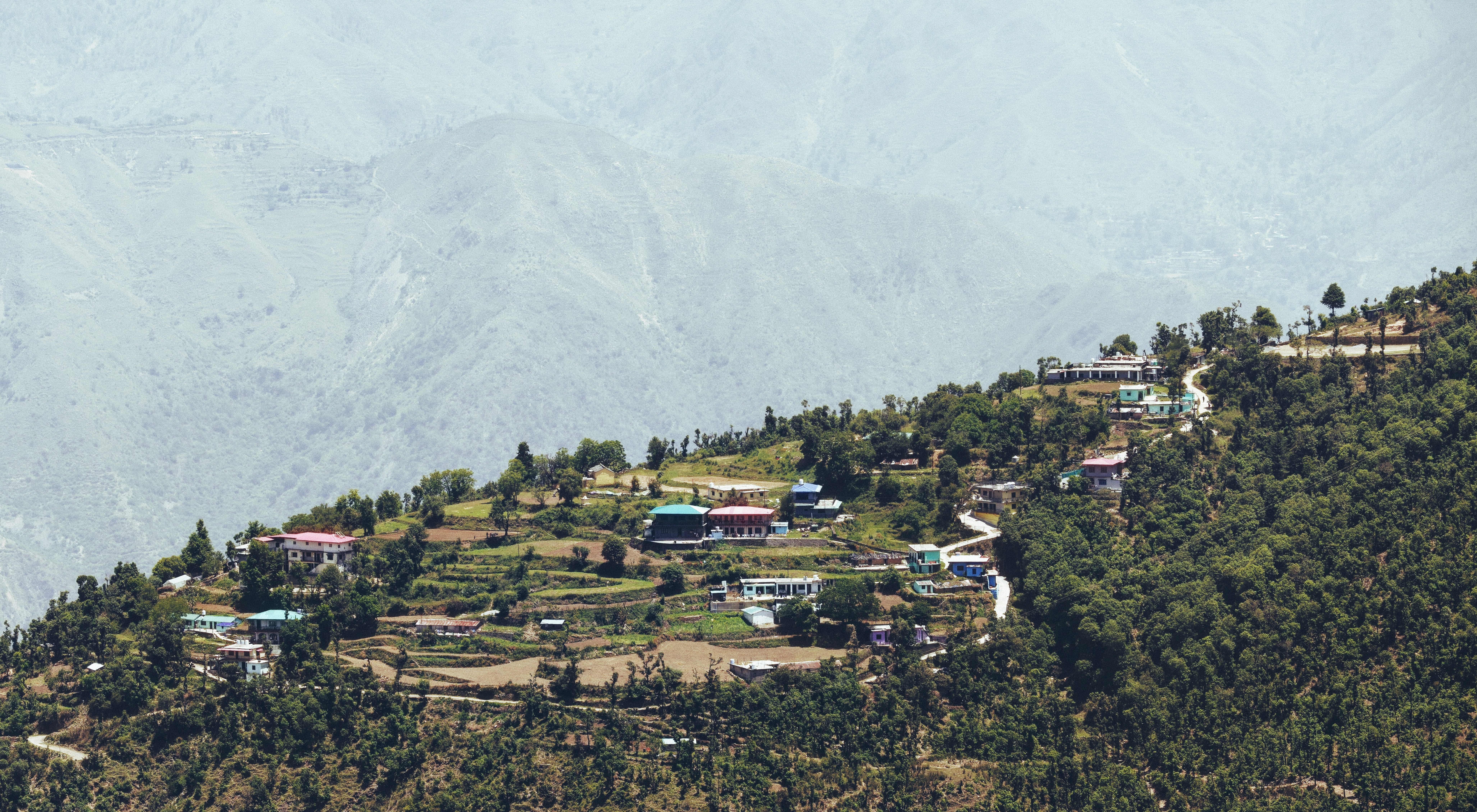 Terraced Village Crowned by Pine-Streaked Ridge