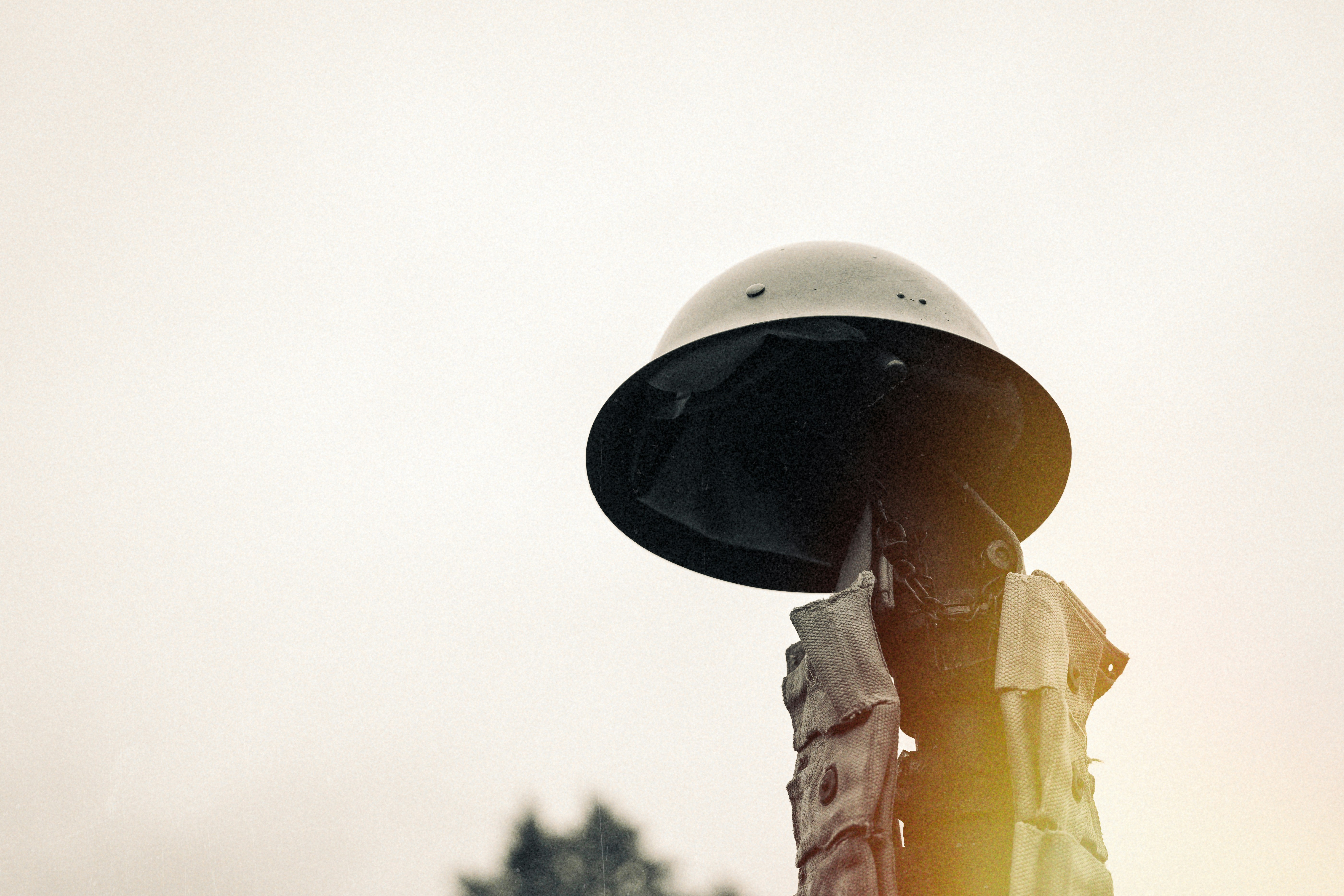 Helmeted silhouette: a statue-like figure reaching upward with a soft halo