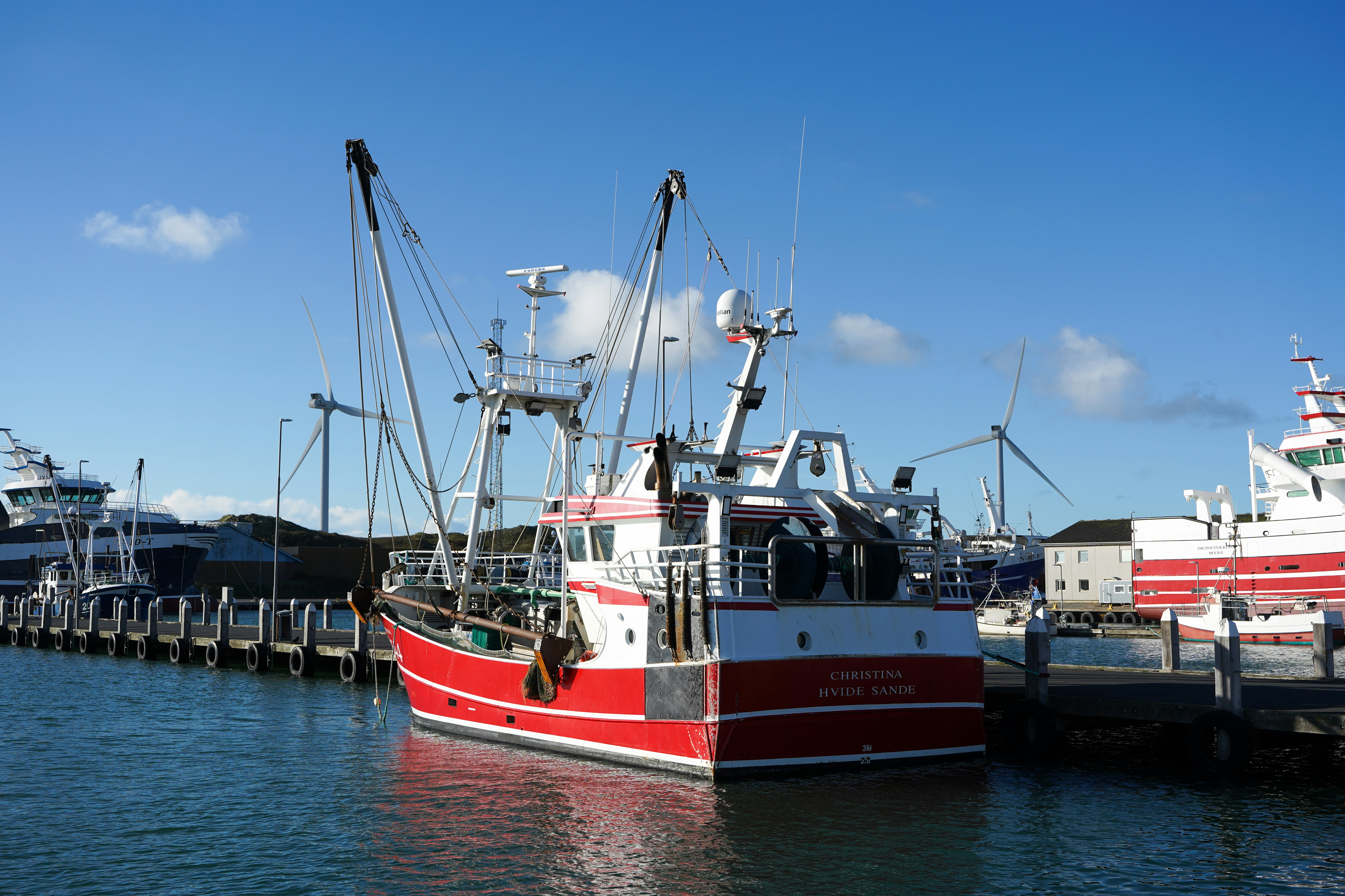 Red Harbor Cutter at the Dock Under a Bright Coastal Sky