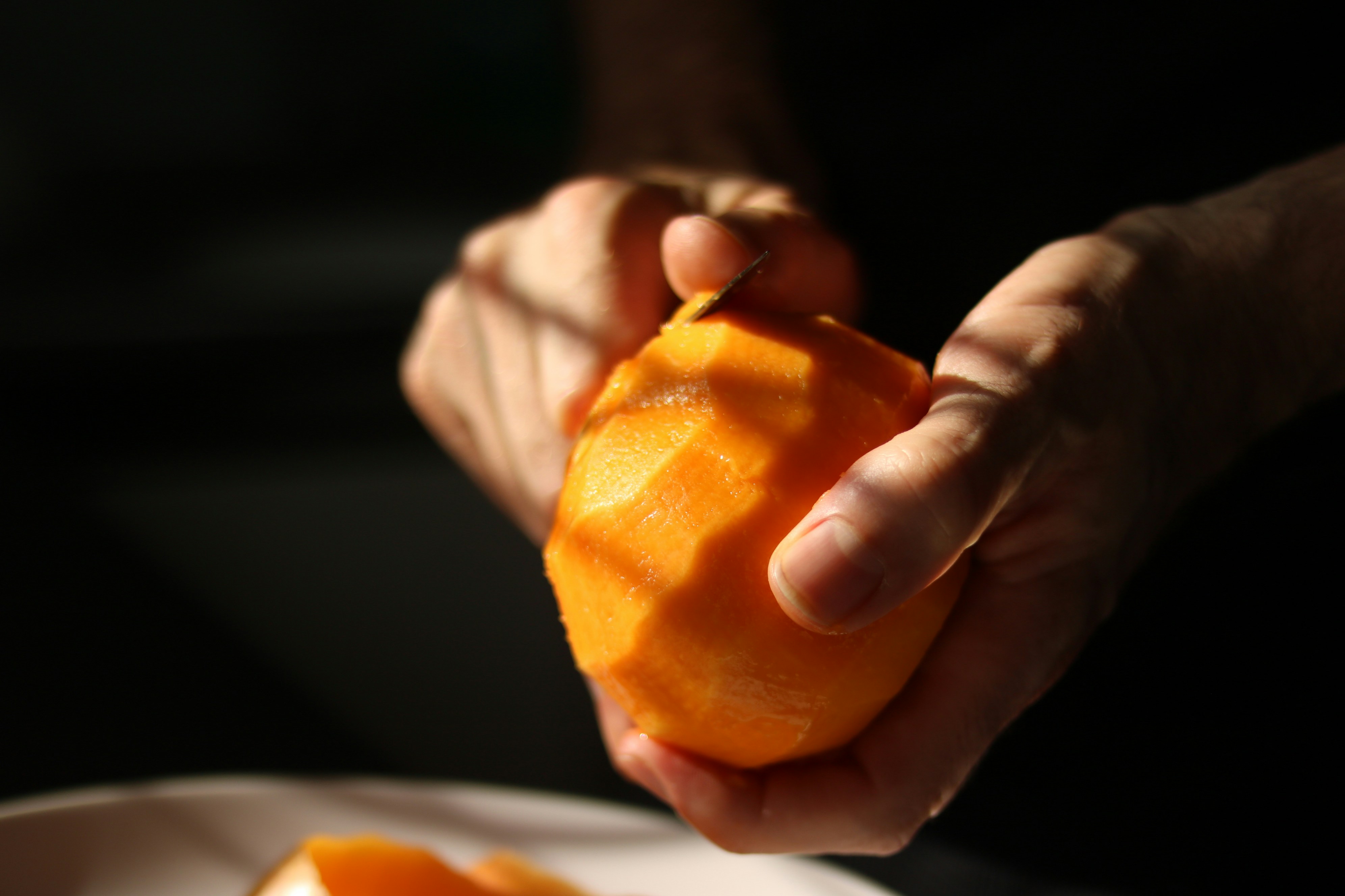 Citrus Craft: Hands Work a Fresh Peel Under Soft Spotlight