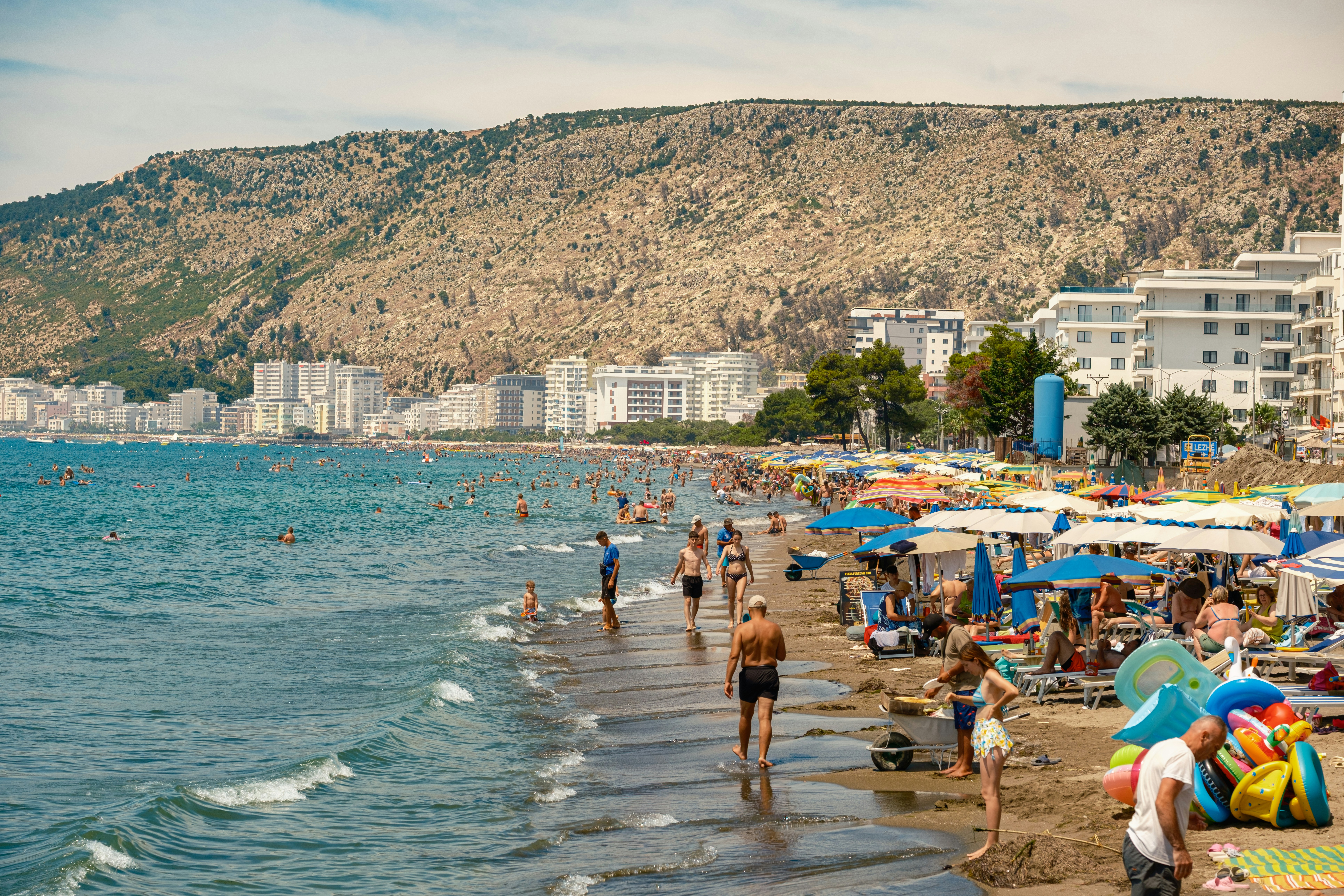 Coastal Beachfront Rhythm: Sunseekers, Umbrellas, and Gentle Waves