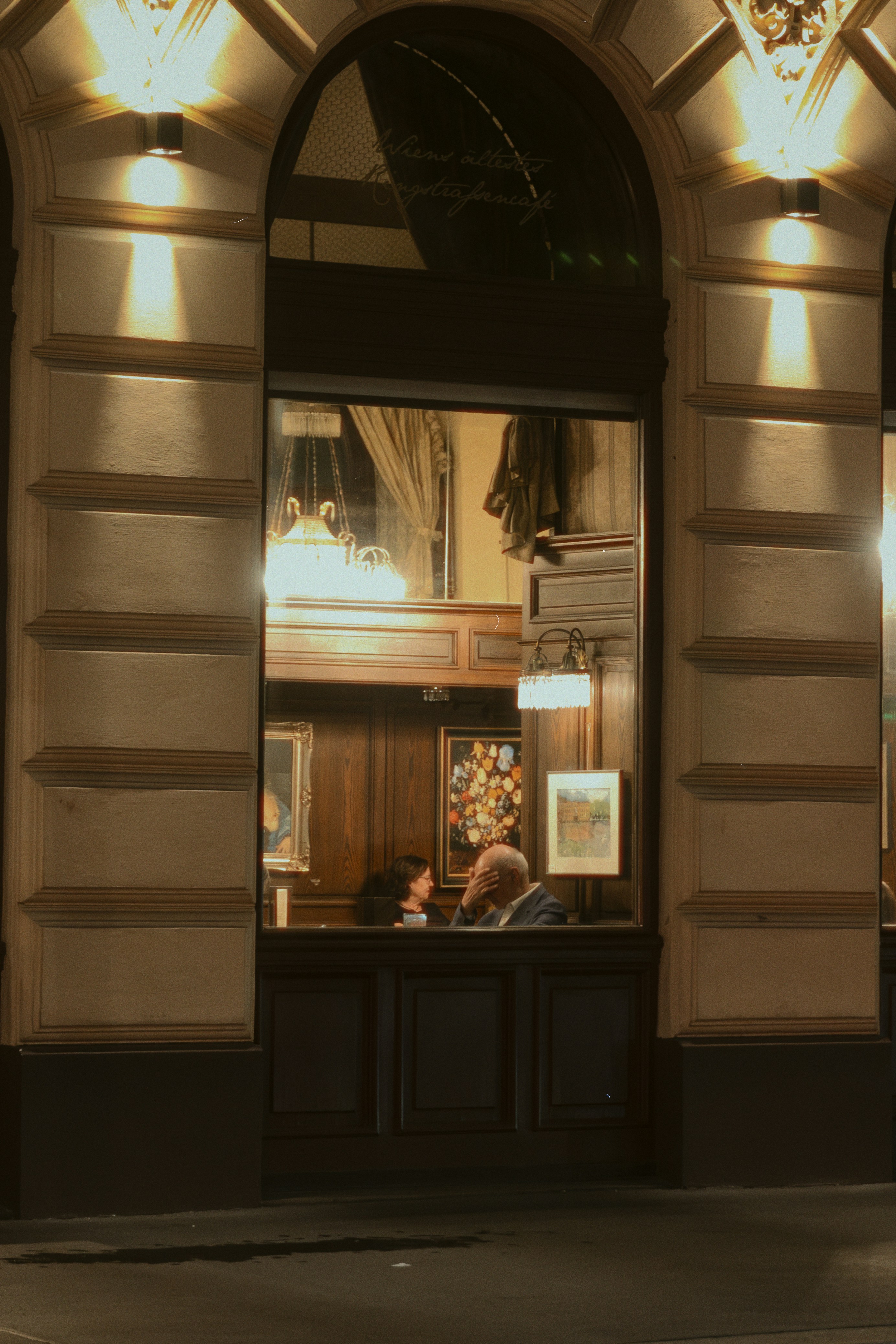 Warm Radiance in a Corner Bar: Intimate Conversation Through a Front Window