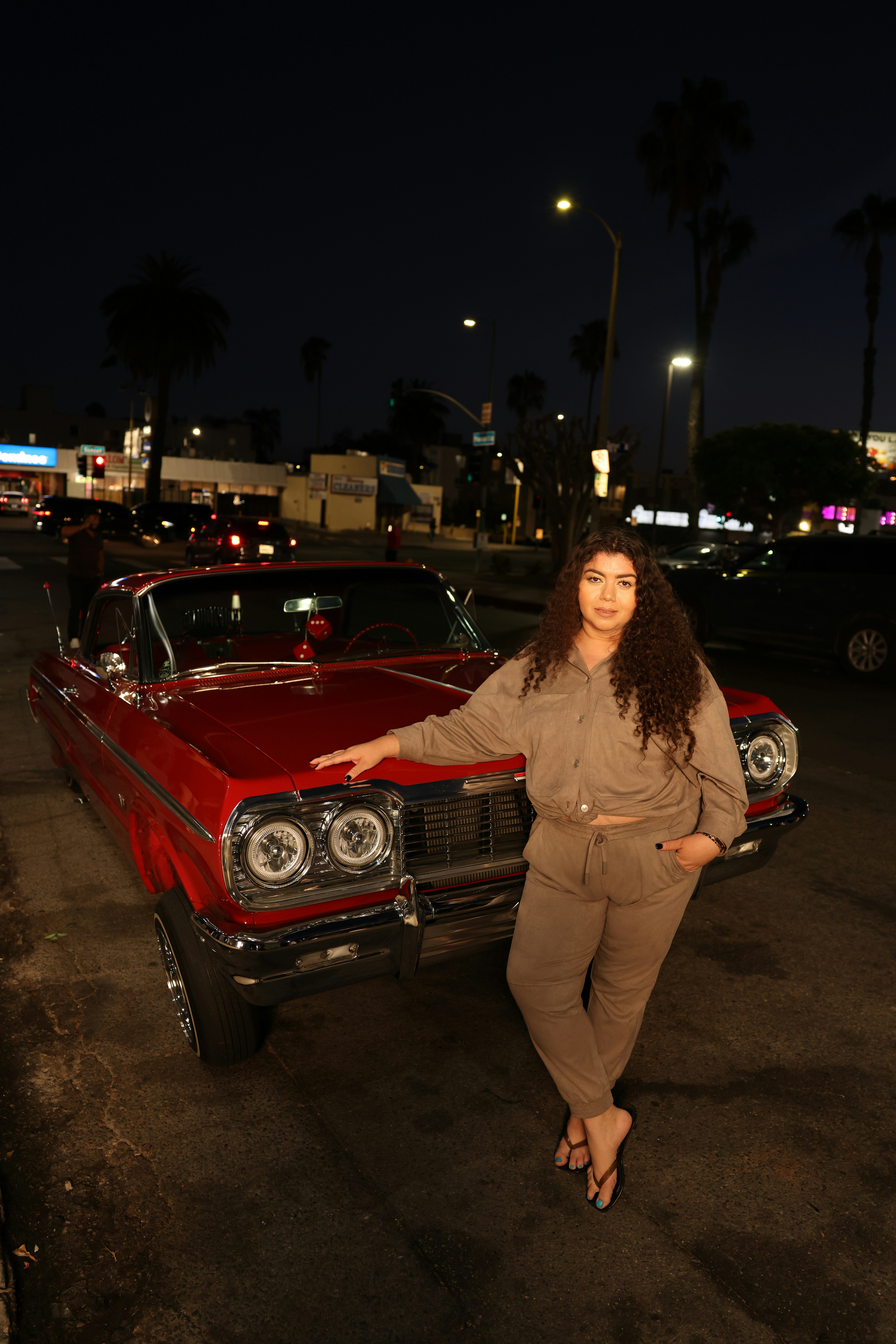 Curved curls, chrome and night lights: a portrait with a vintage red ride