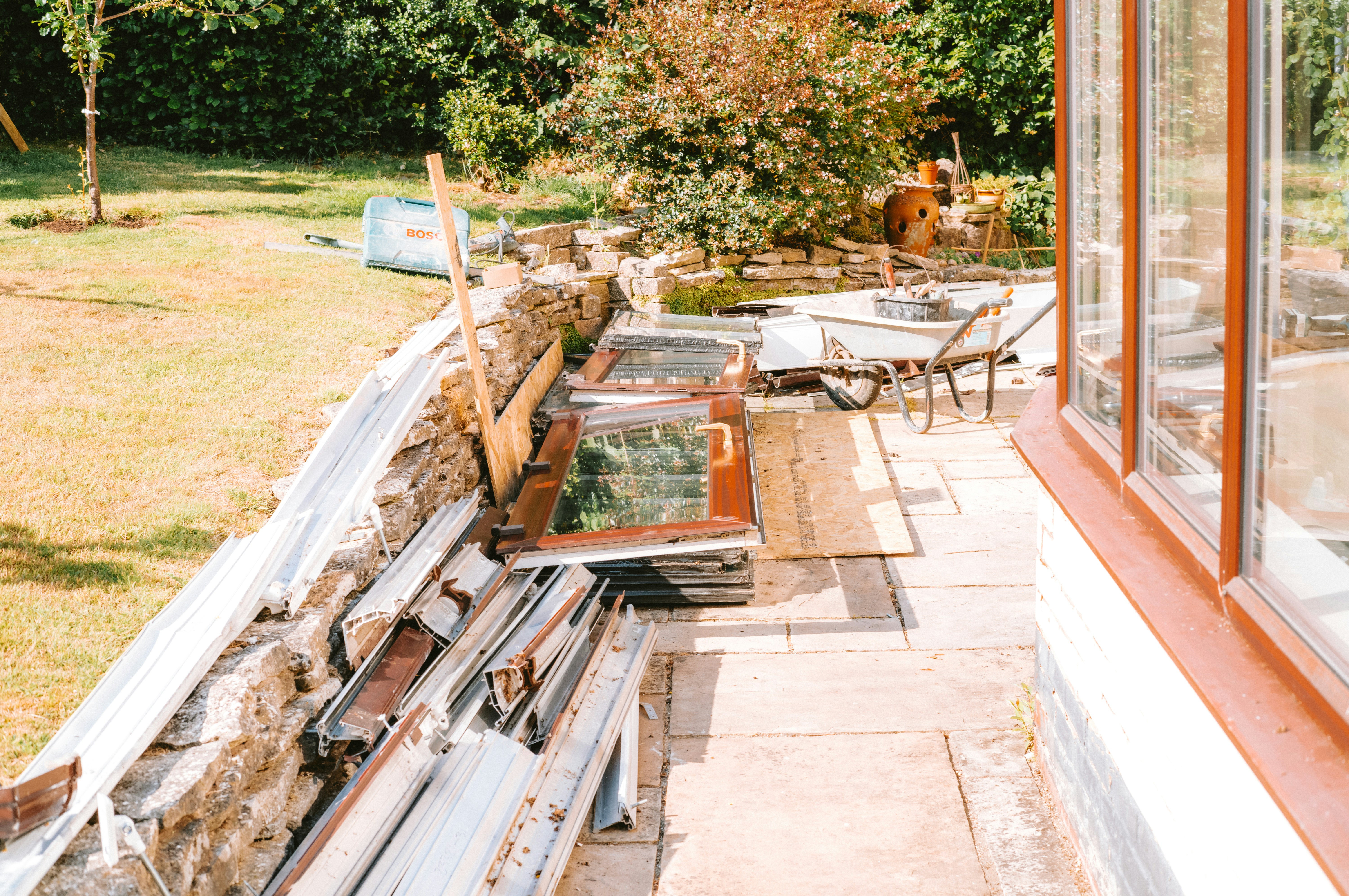 Sunny patio with stacked materials and cold frames