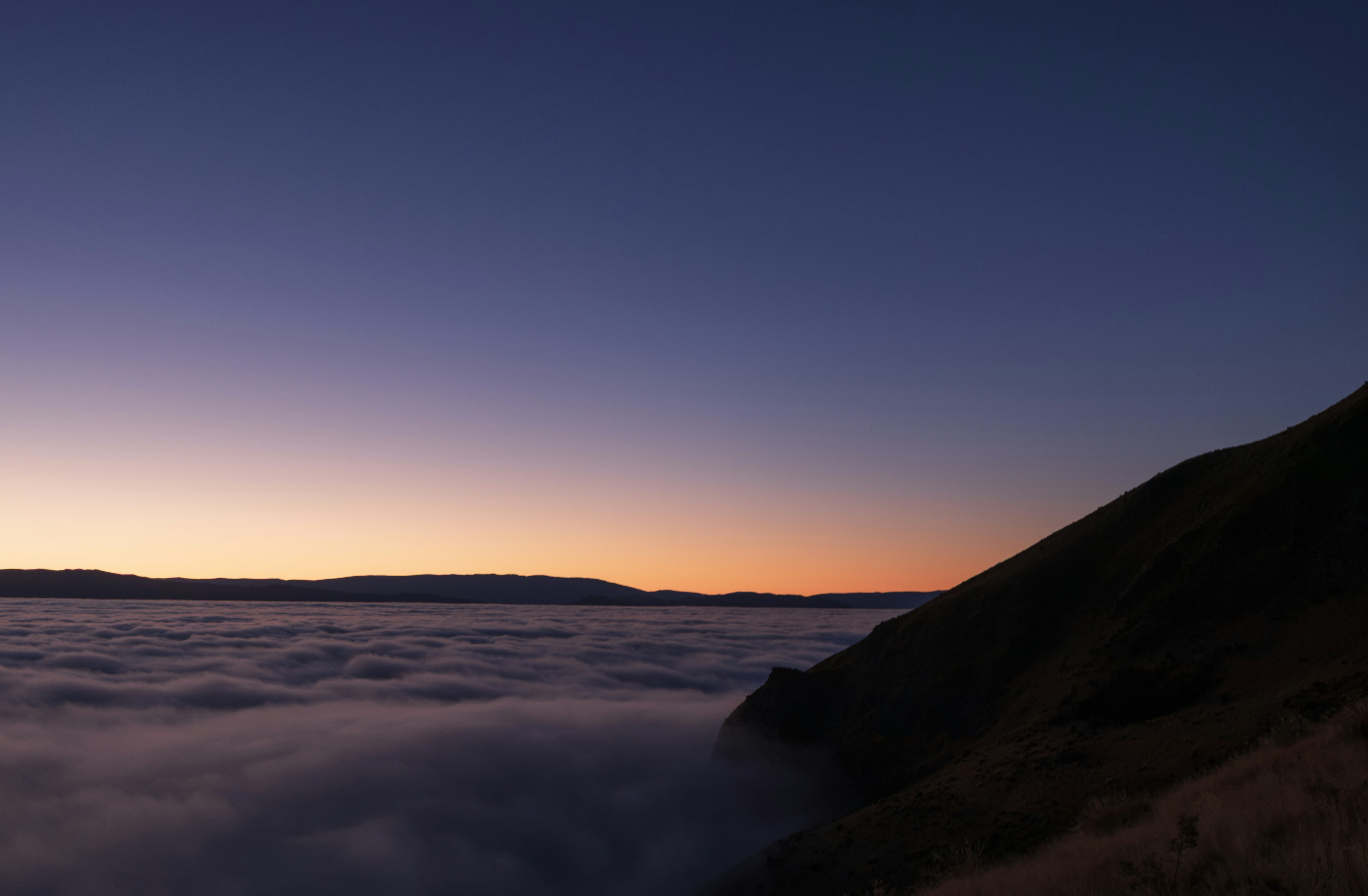 Dusk Above a Sea of Clouds Over the Mountain Rim
