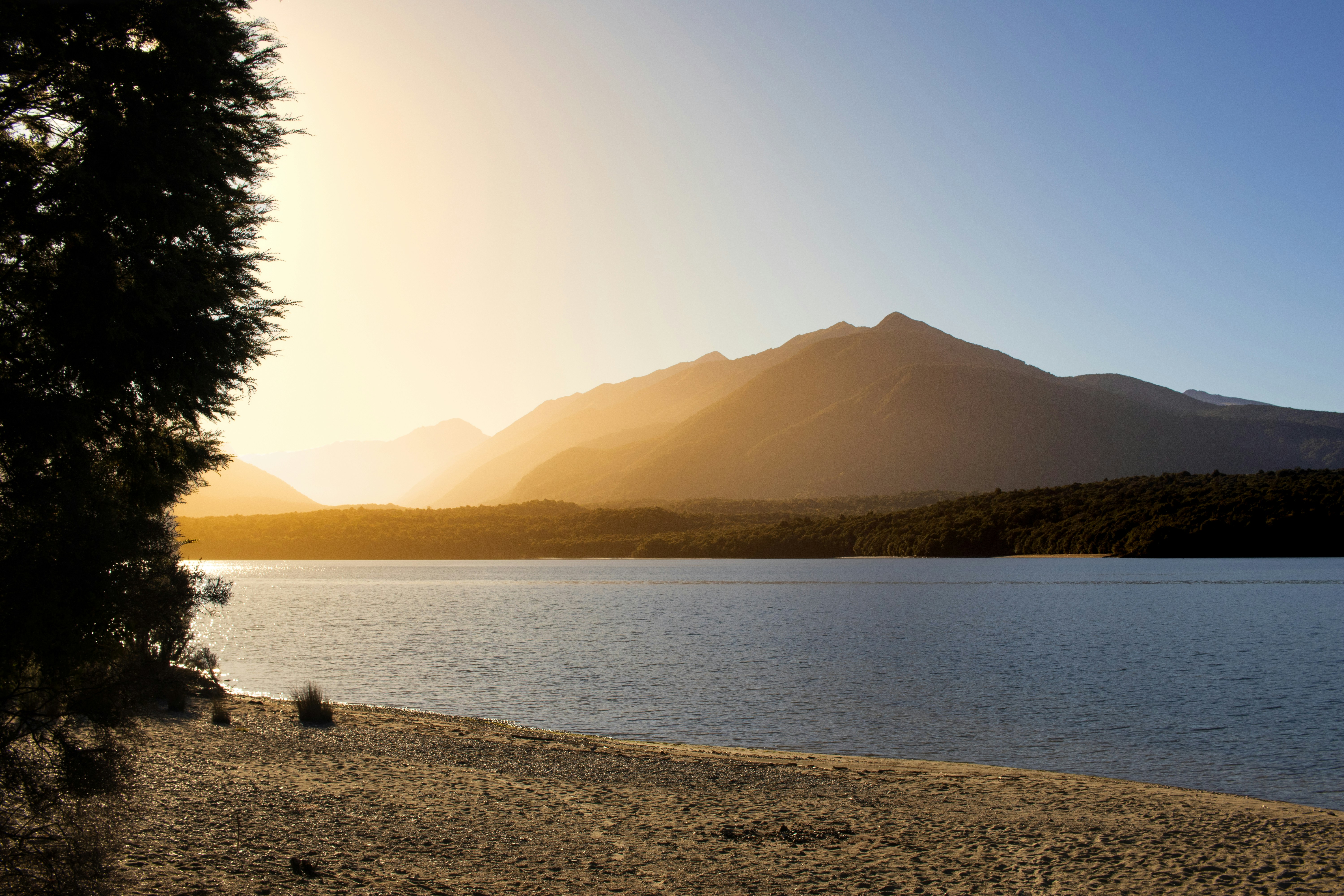 Golden Hour by the Lake: Mountain Silhouette at Dusk