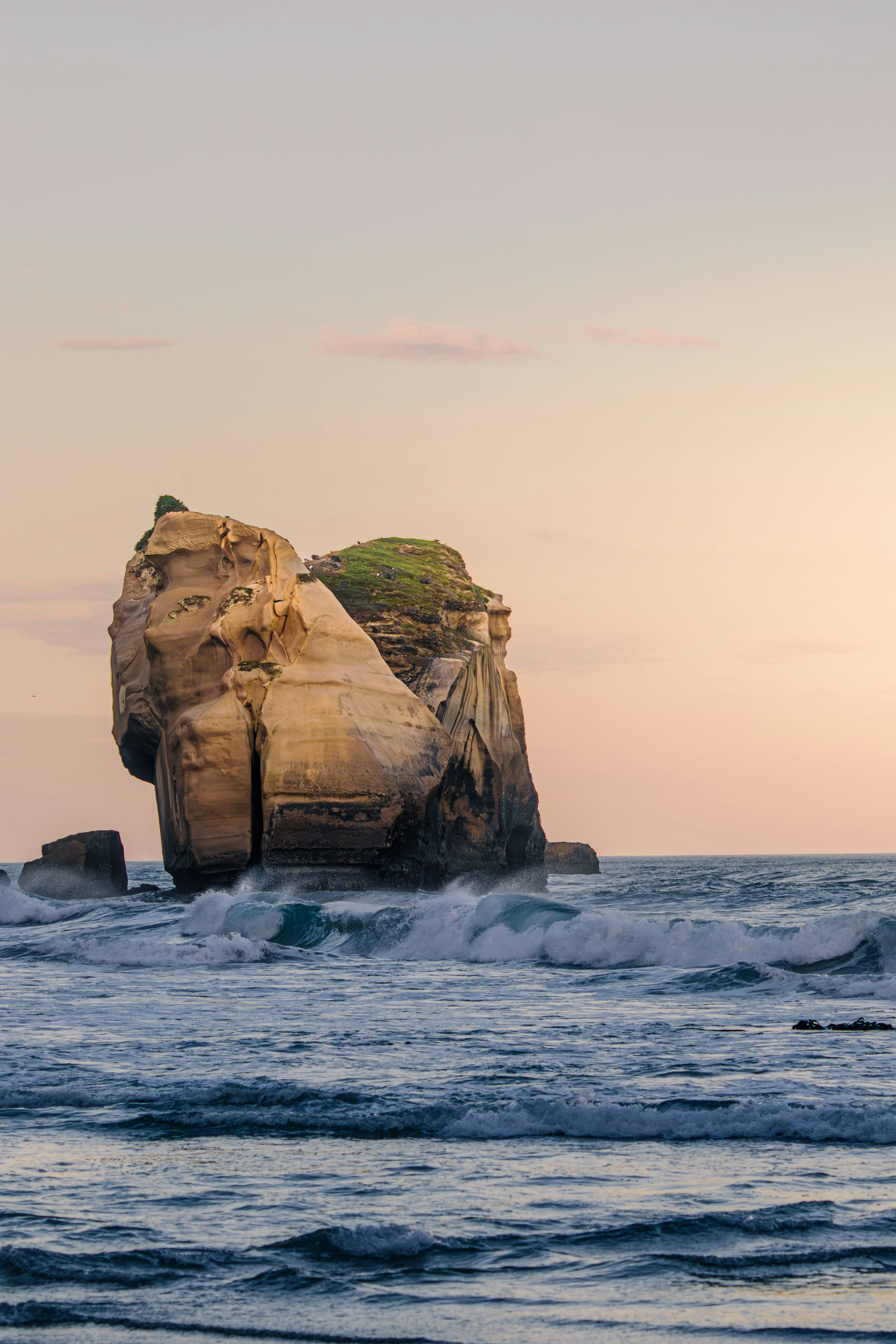 Sea Sentinel: A Battered Rock Emerges from the Atlantic Calm