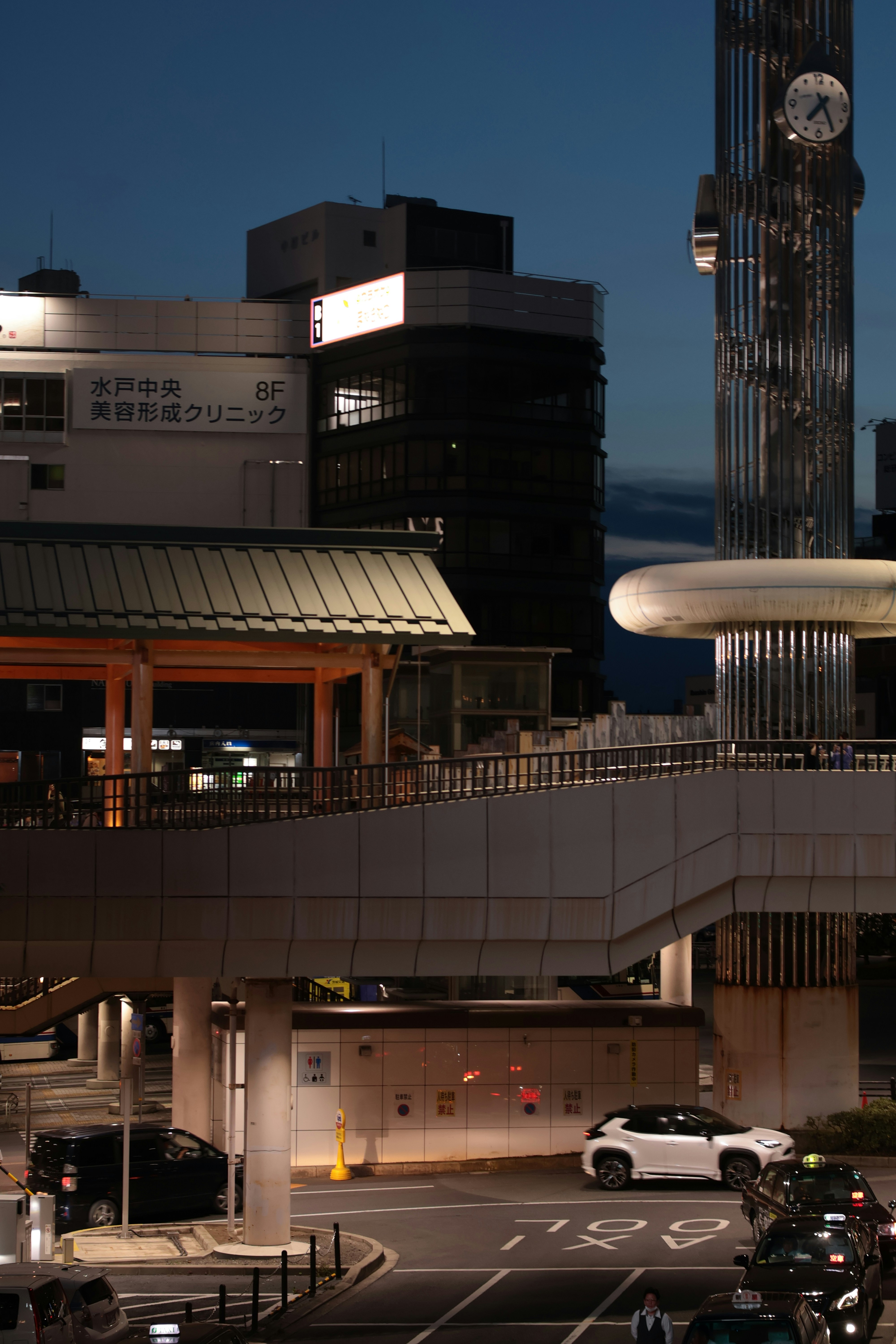 Night ascent: cityscape overpass under a clock-topped sculpture