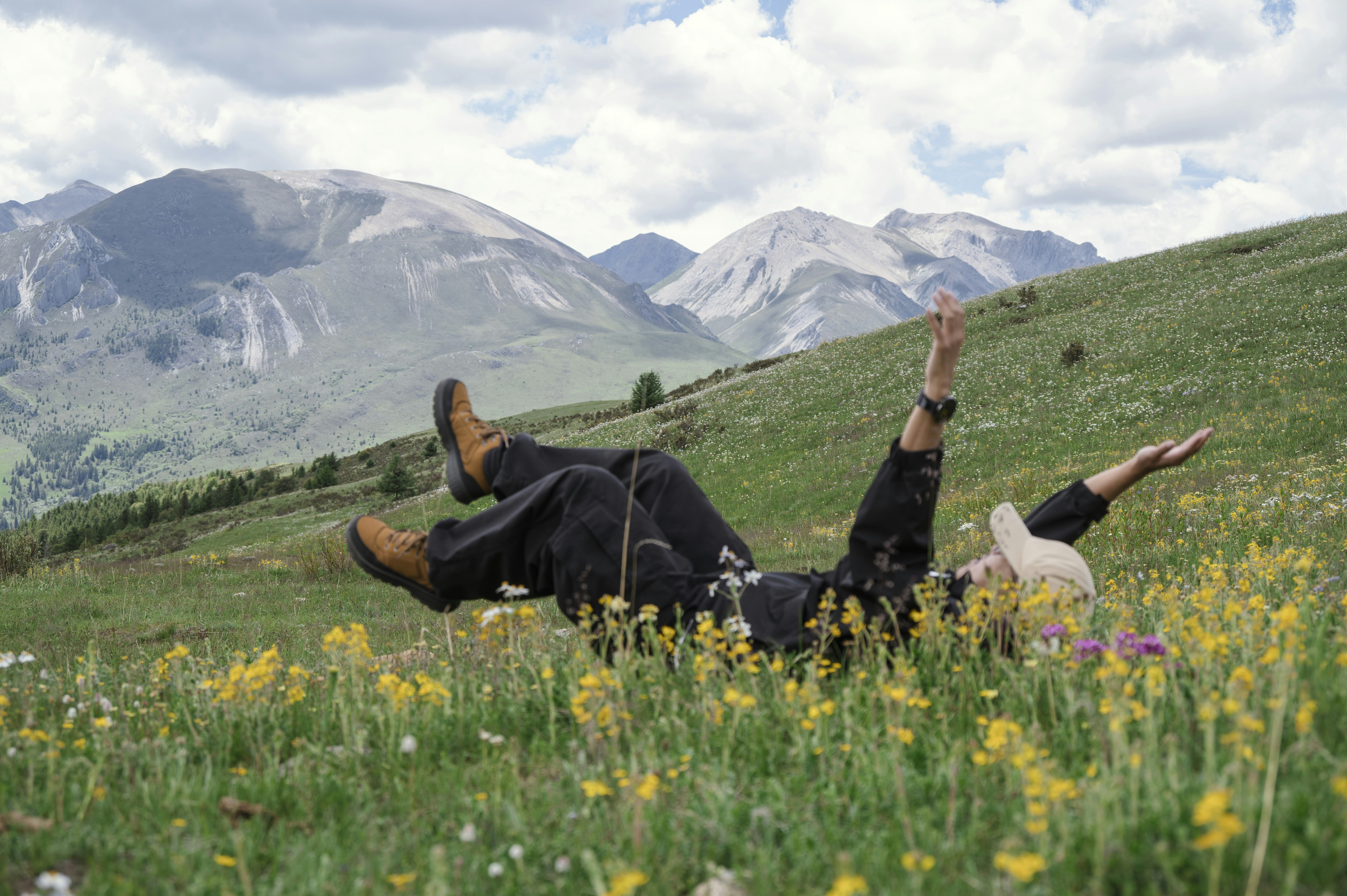 Blue‑sky slide: a traveler’s playful tumble among alpine wildflowers