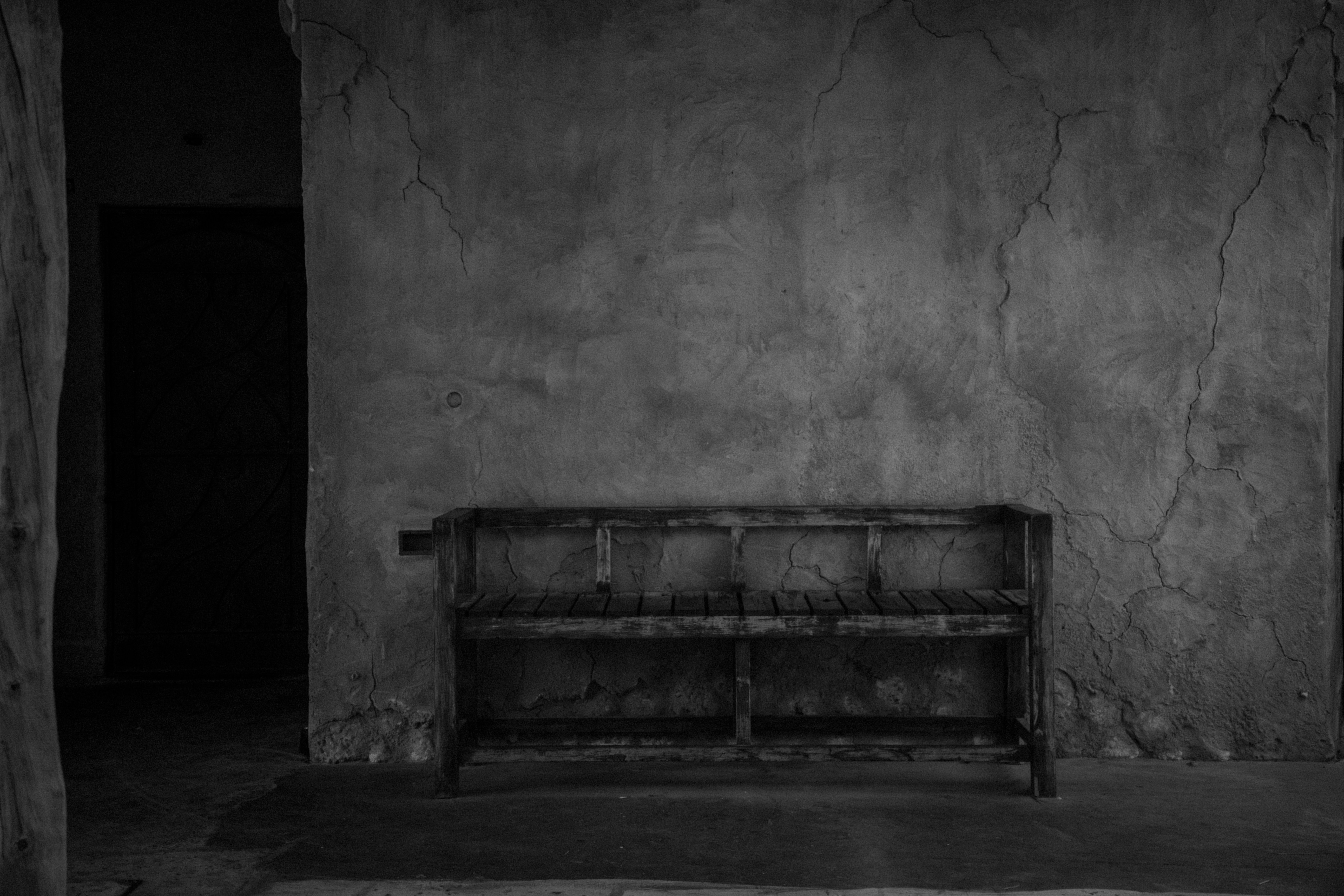 The Silent Bench Against a Cracked Wall