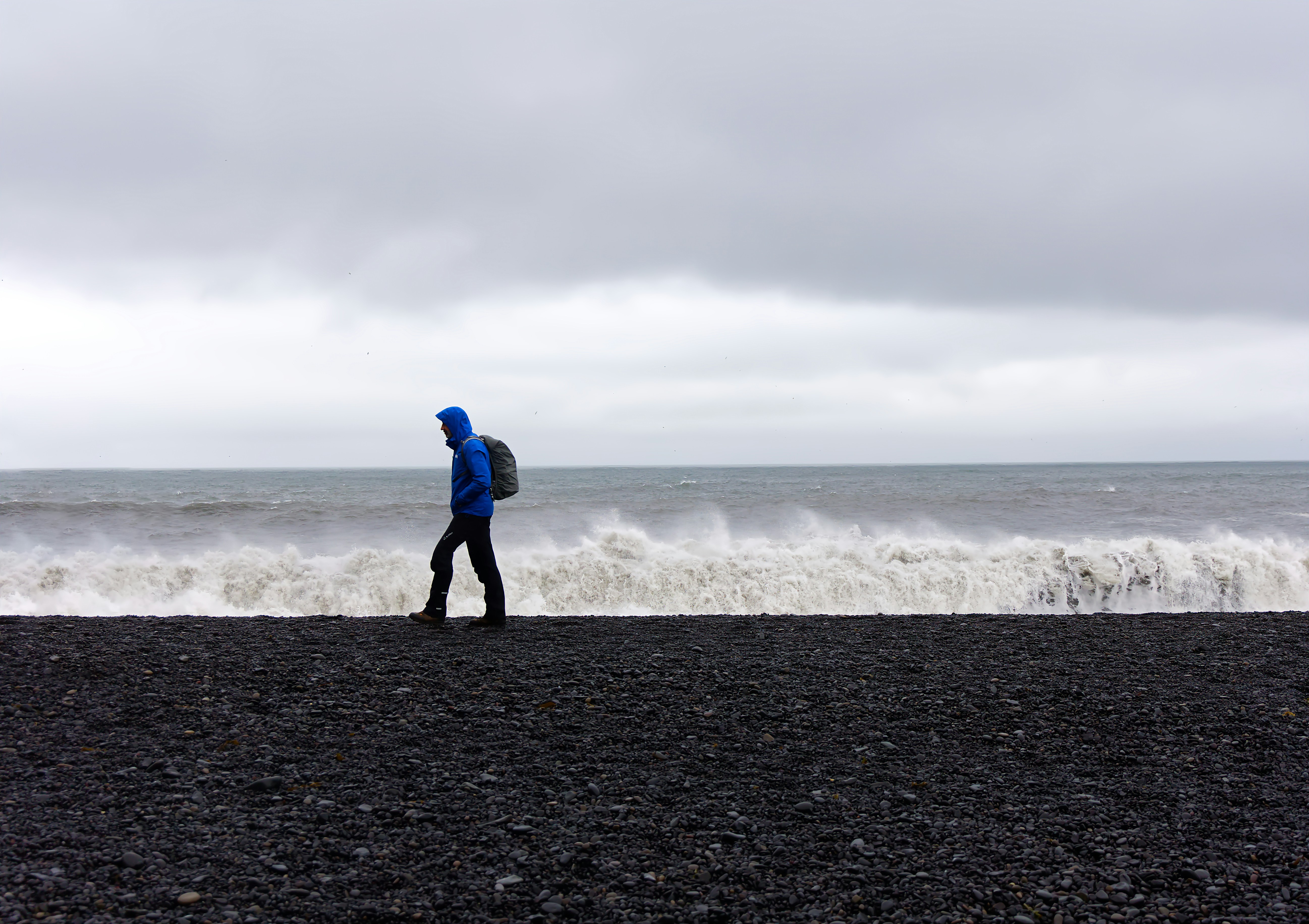 Blue-Clad Wanderer on a Pebble Shore