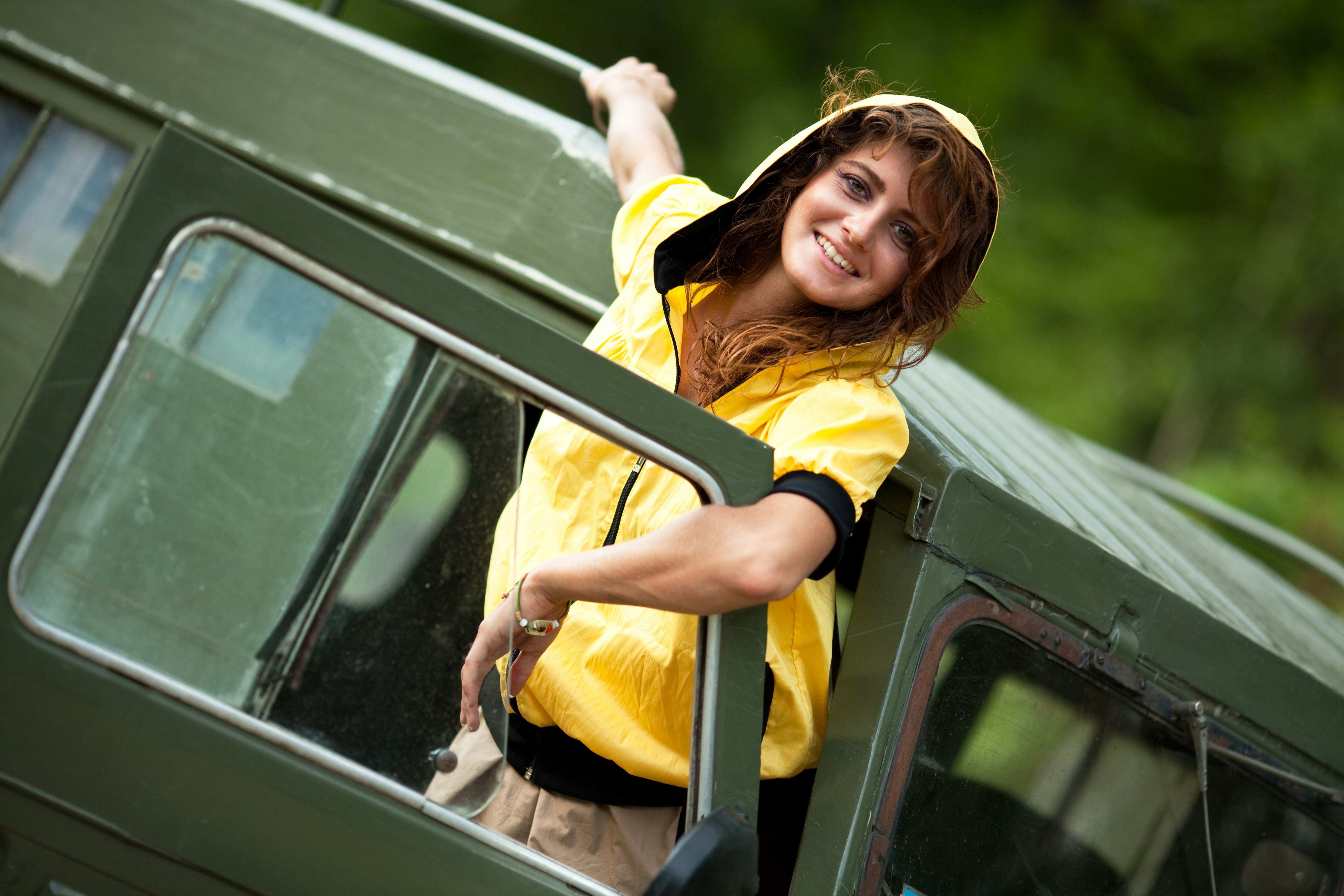 Smiling Explorer: Leaning from the Cab with a Bright Yellow Cuff