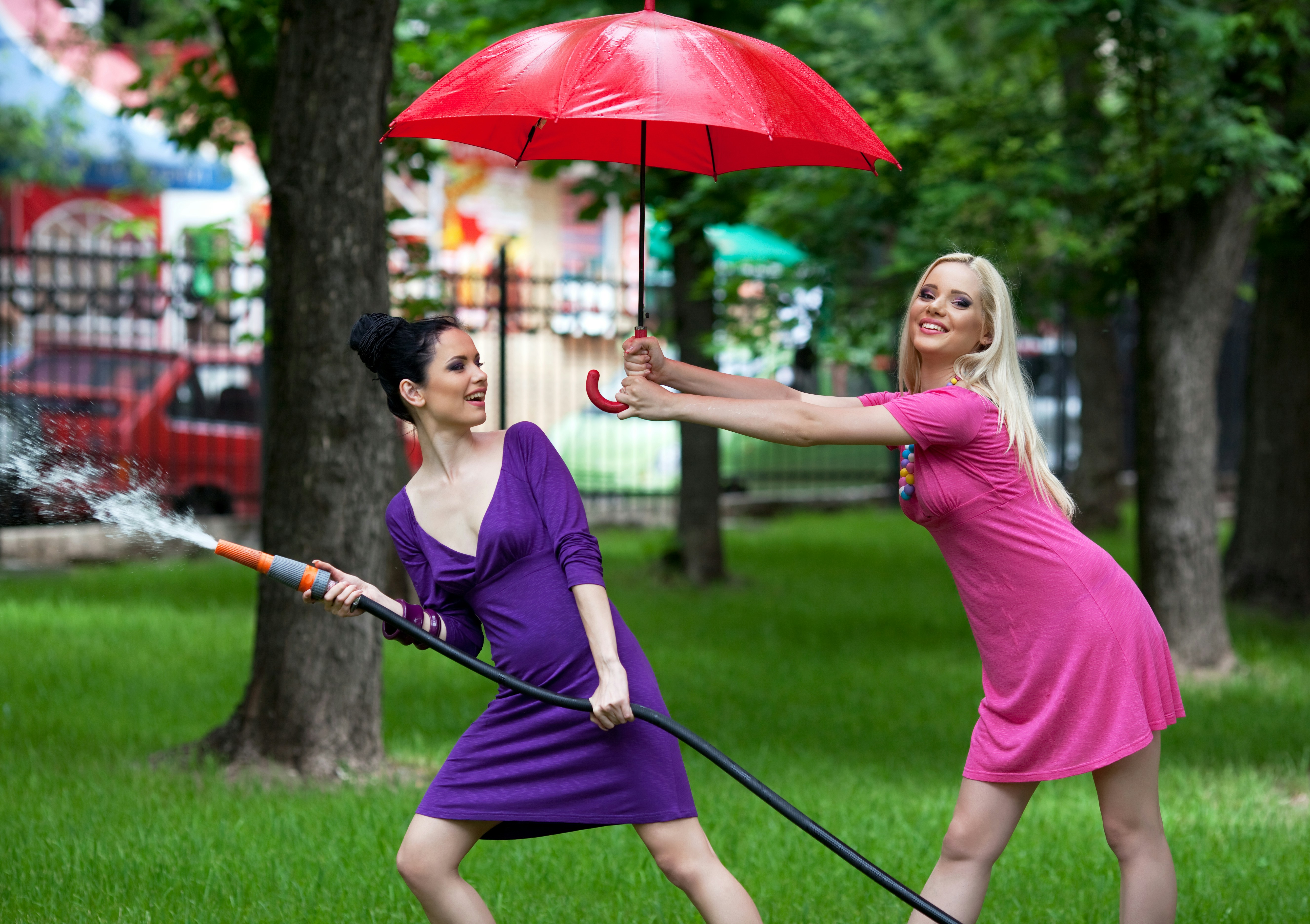 Umbrella Tug: Two Friends Reclaiming the Park with a Splash of Color
