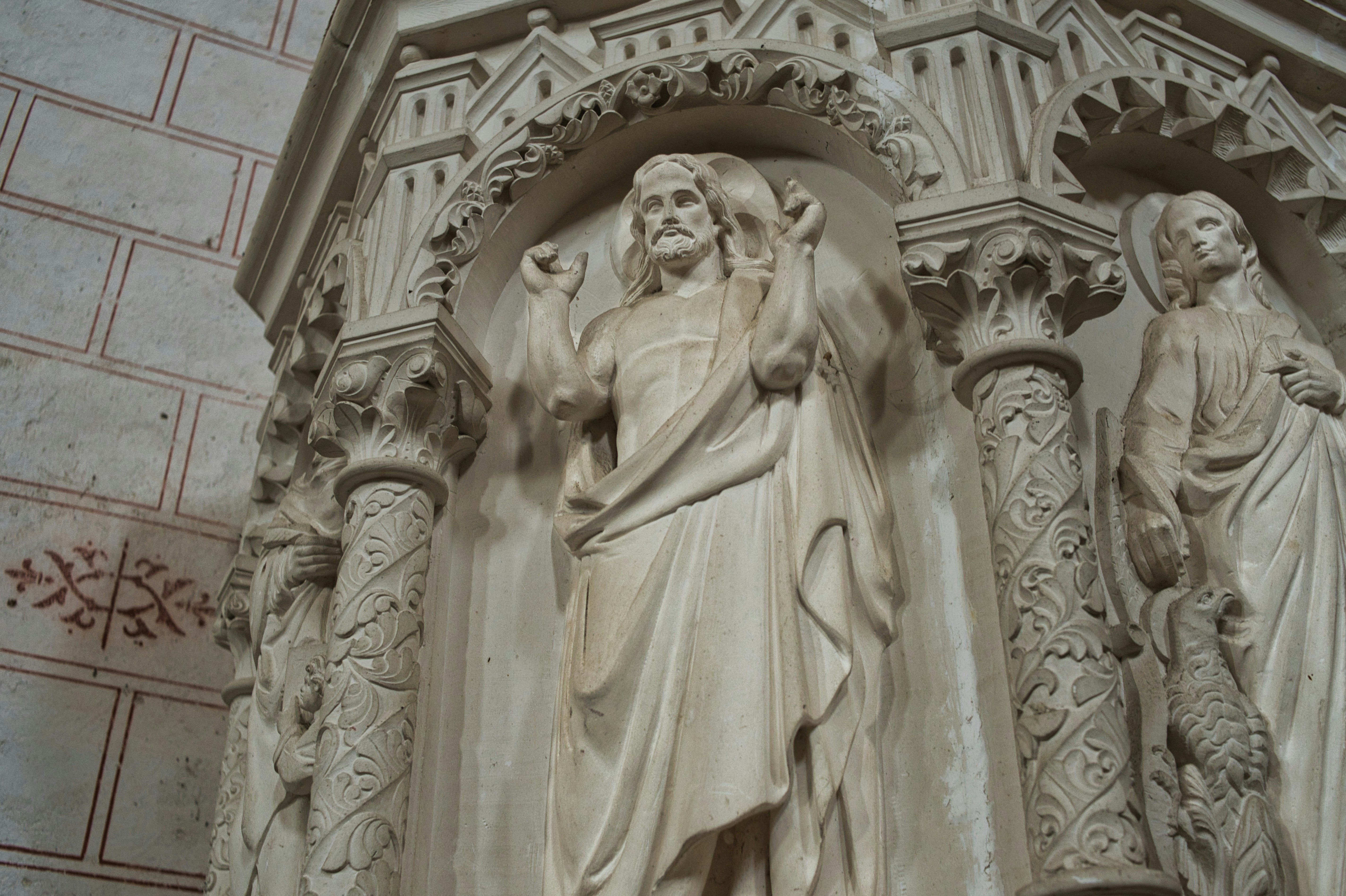 Stone Sermon: A Heroic Carved Figure Beneath Ornate Cathedral Carvings