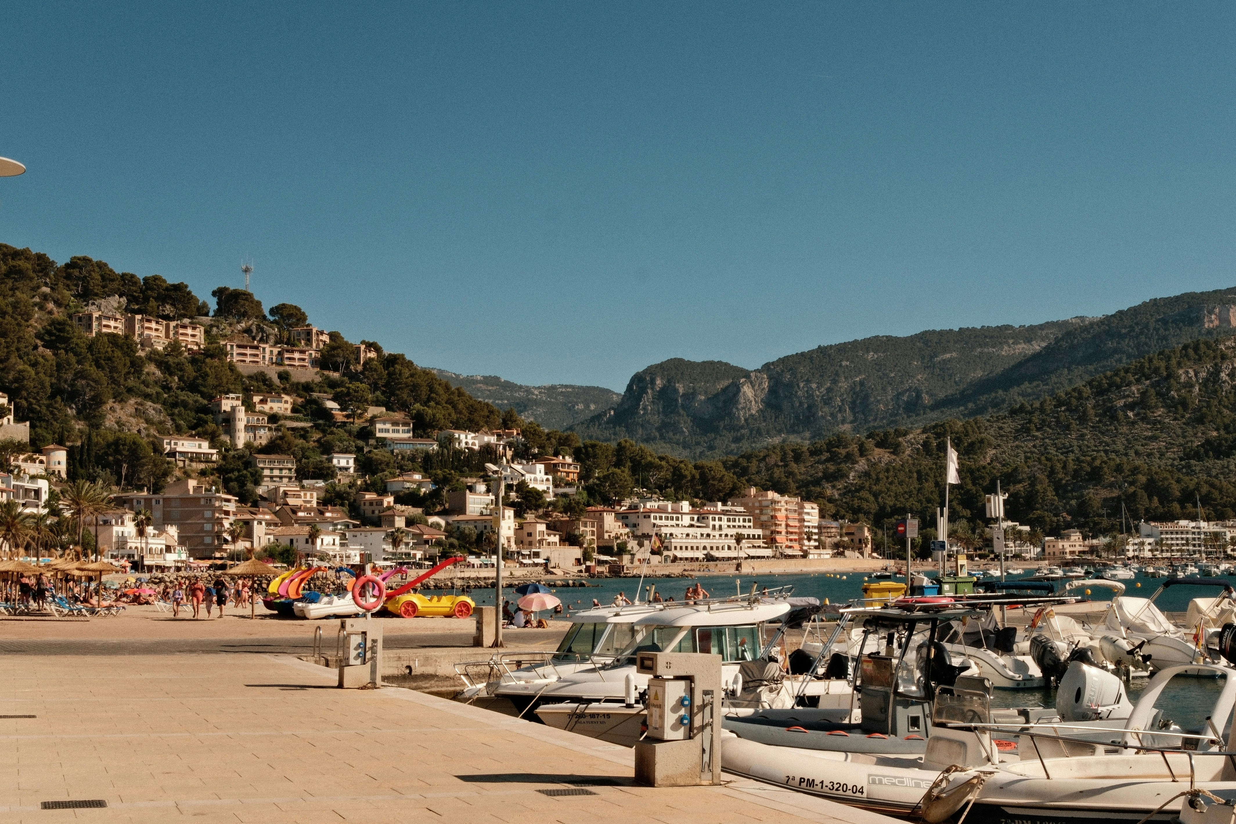 Harbor Playground: Boats, Beachfront, and Mountain Backdrop