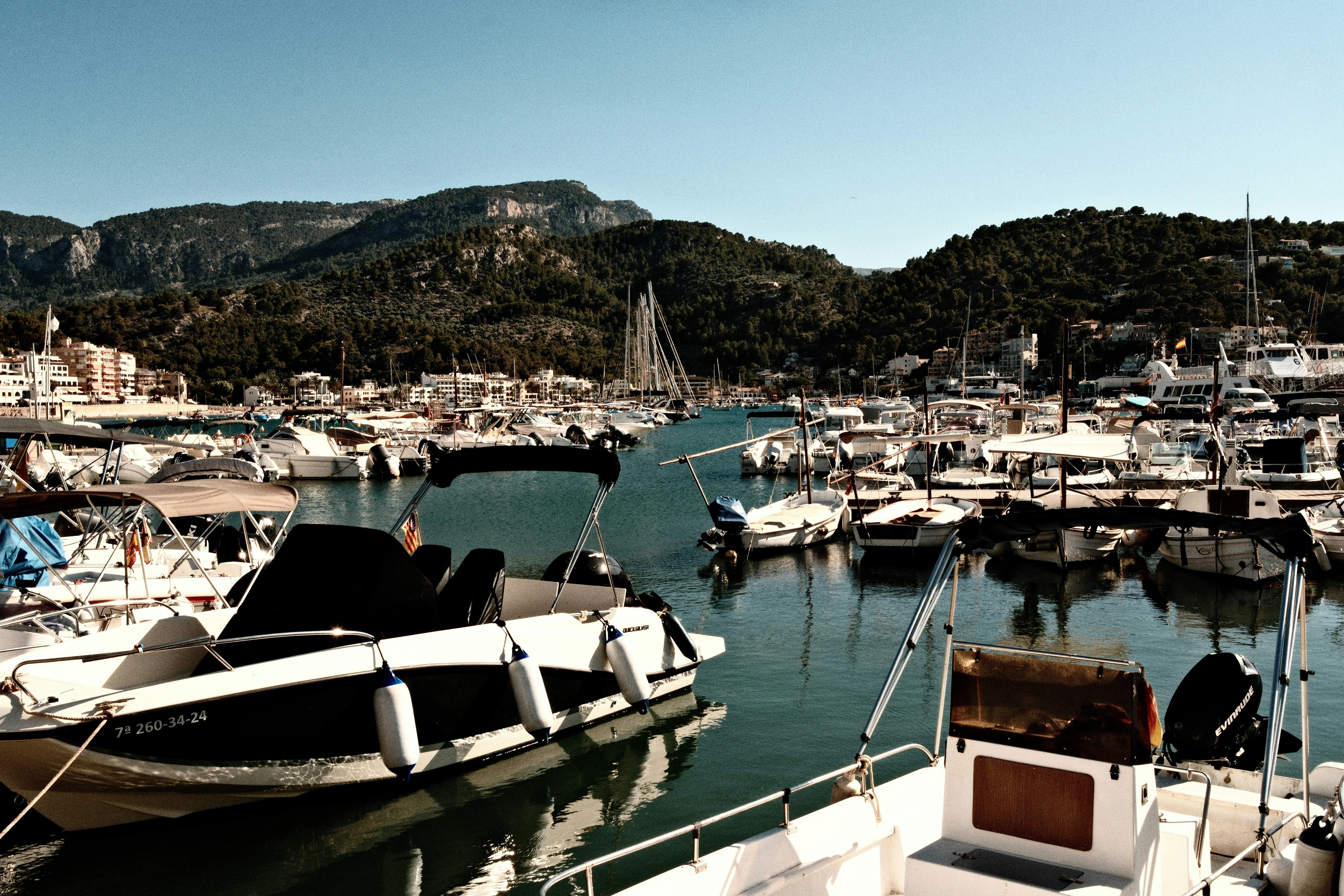 Sunlit Marina: Boats at Rest as Hills Rise in the Distance