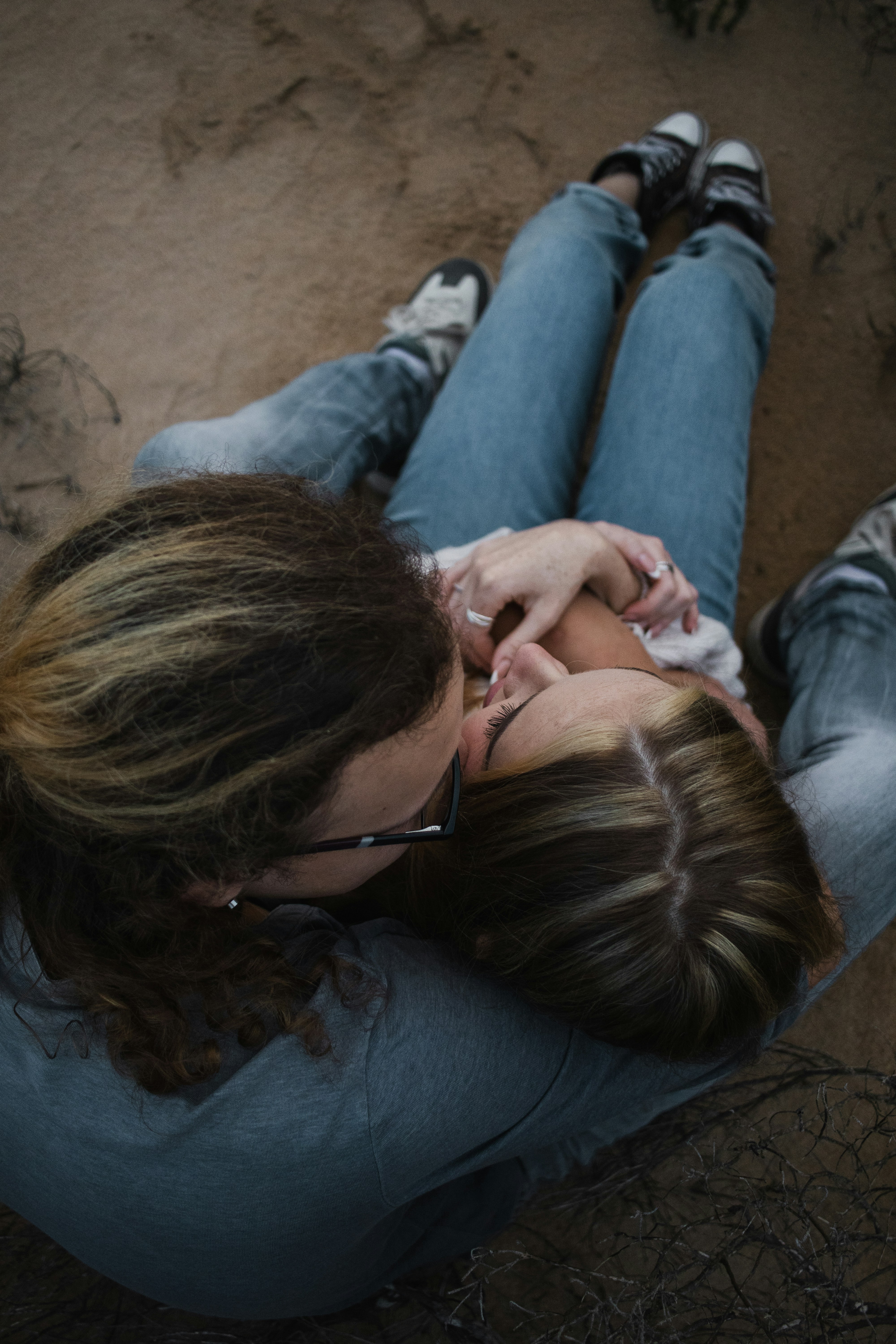 Overhead embrace: two lovers framed in a sandy confession